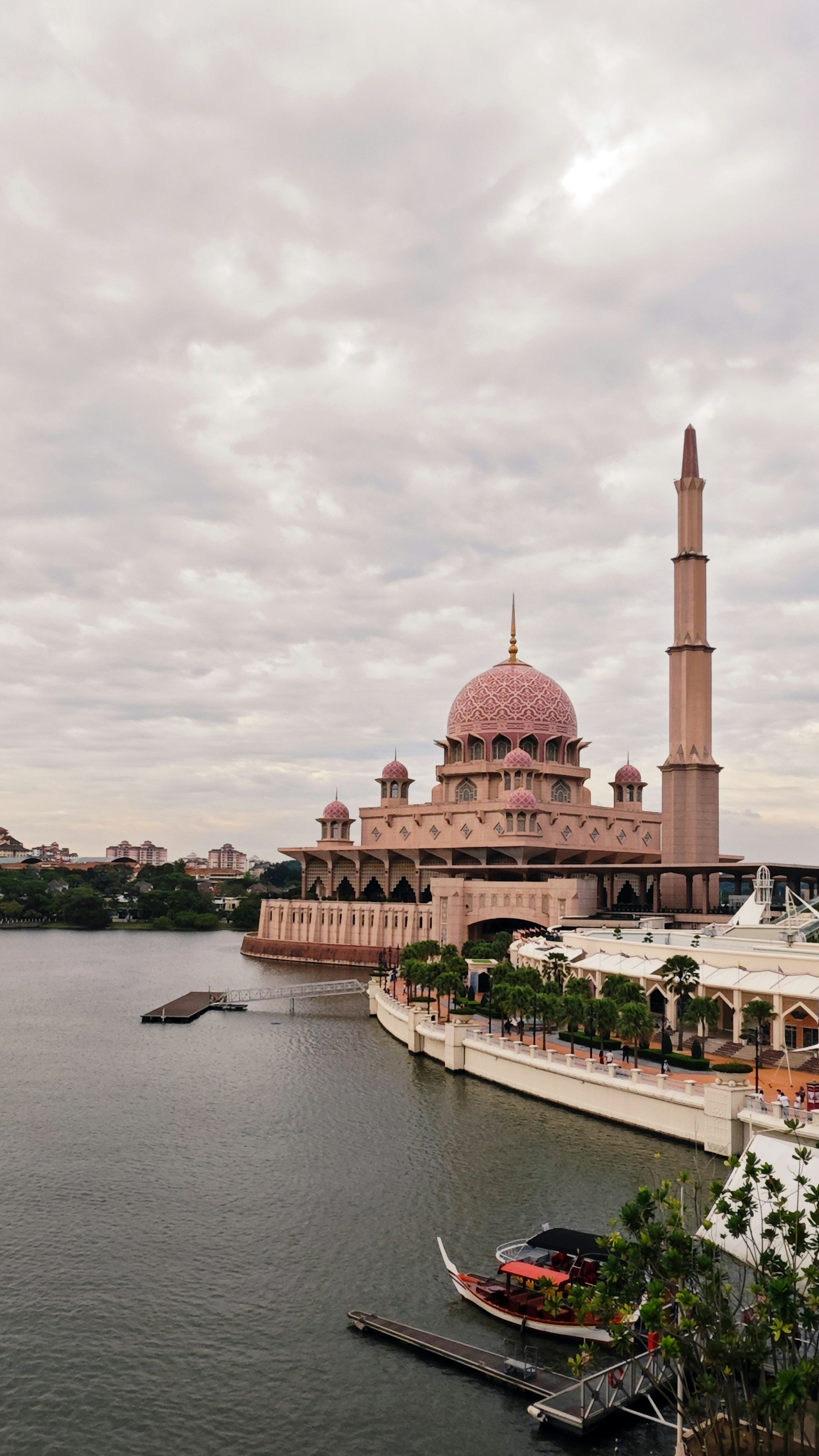 Pink mosque with a tall minaret by the water
