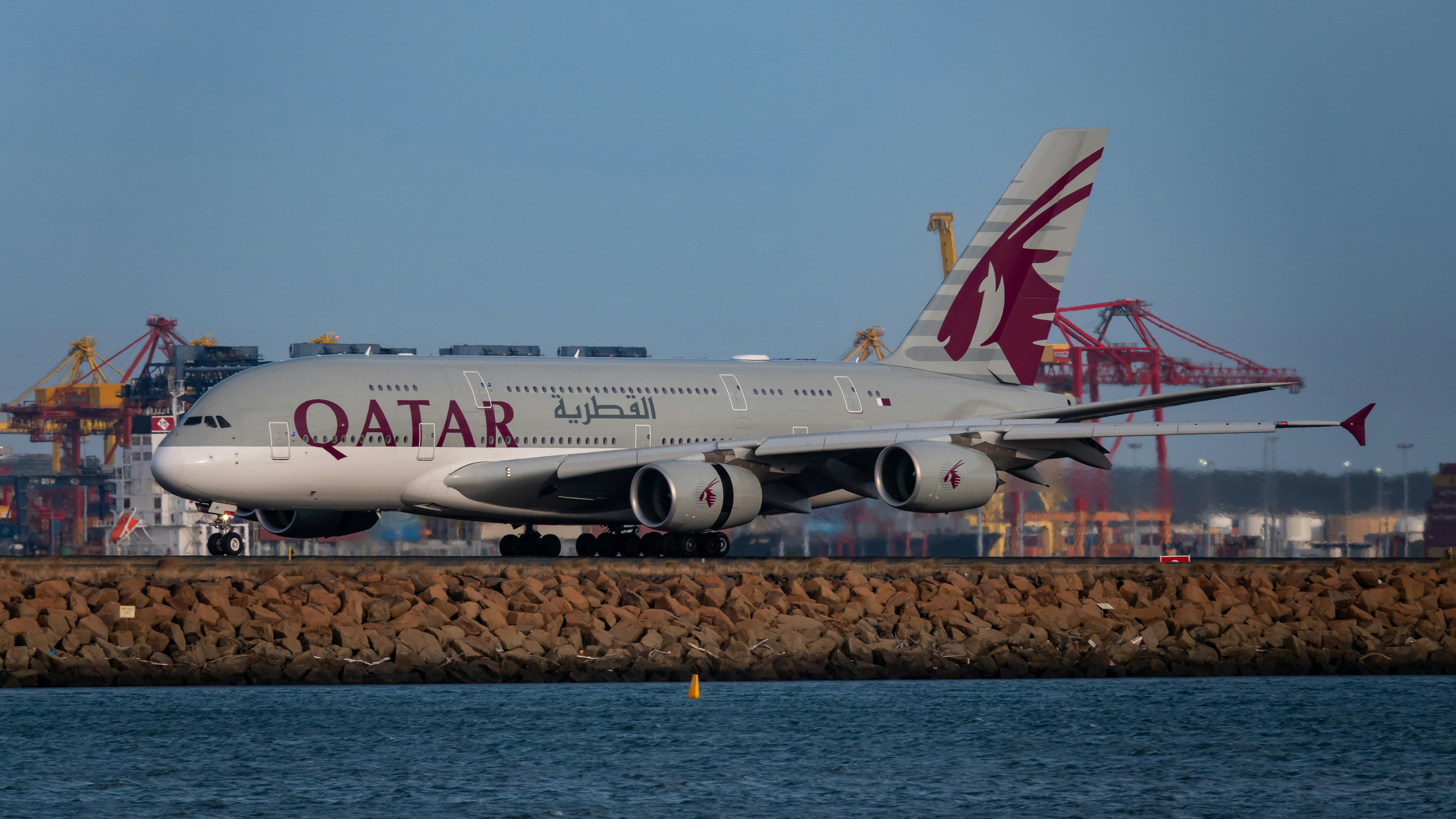Qatar airways airplane taxiing near the water