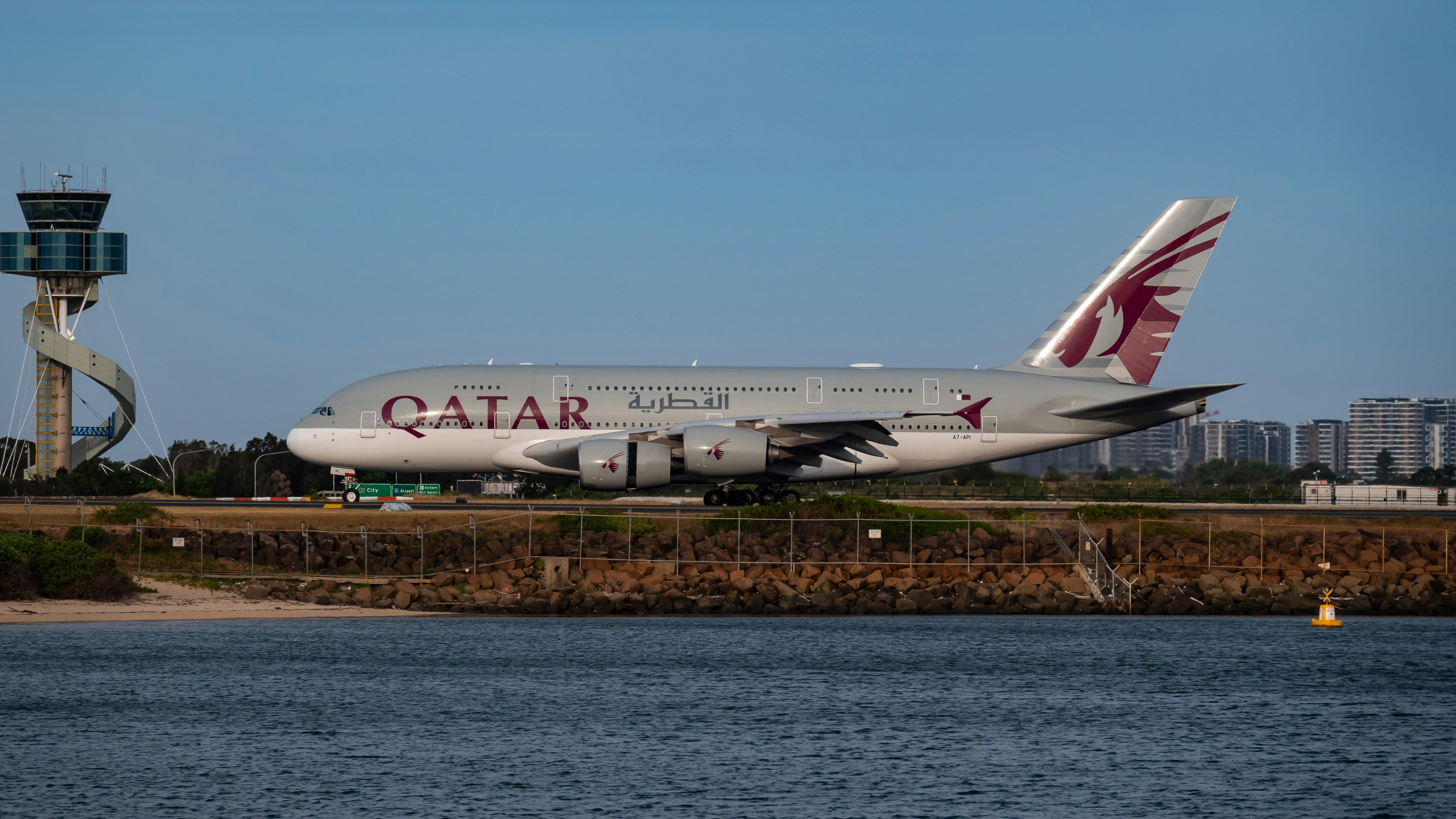 Qatar airways airplane on tarmac near water