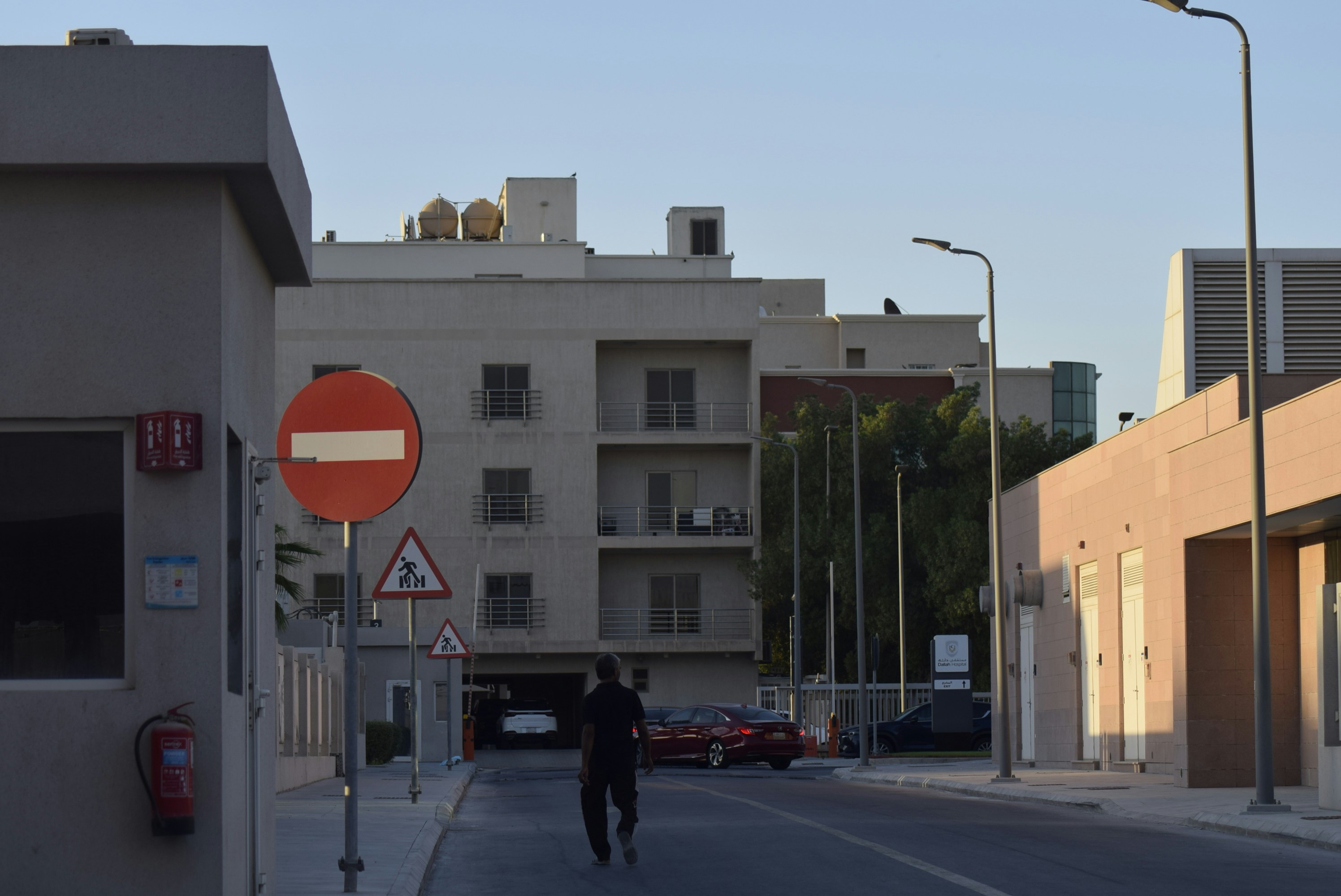 Man walks down street with buildings and signs