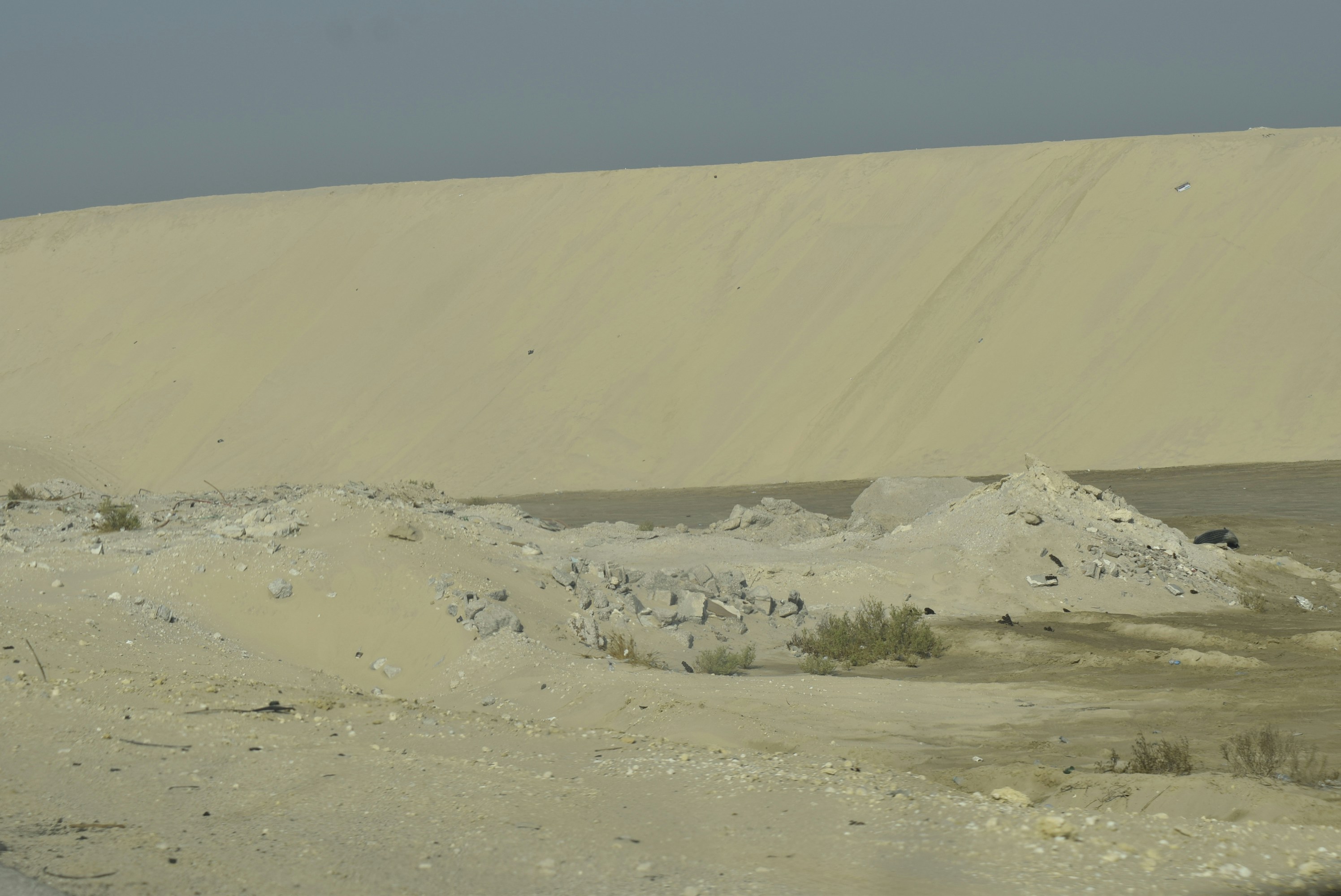 Sandy desert landscape with scattered debris