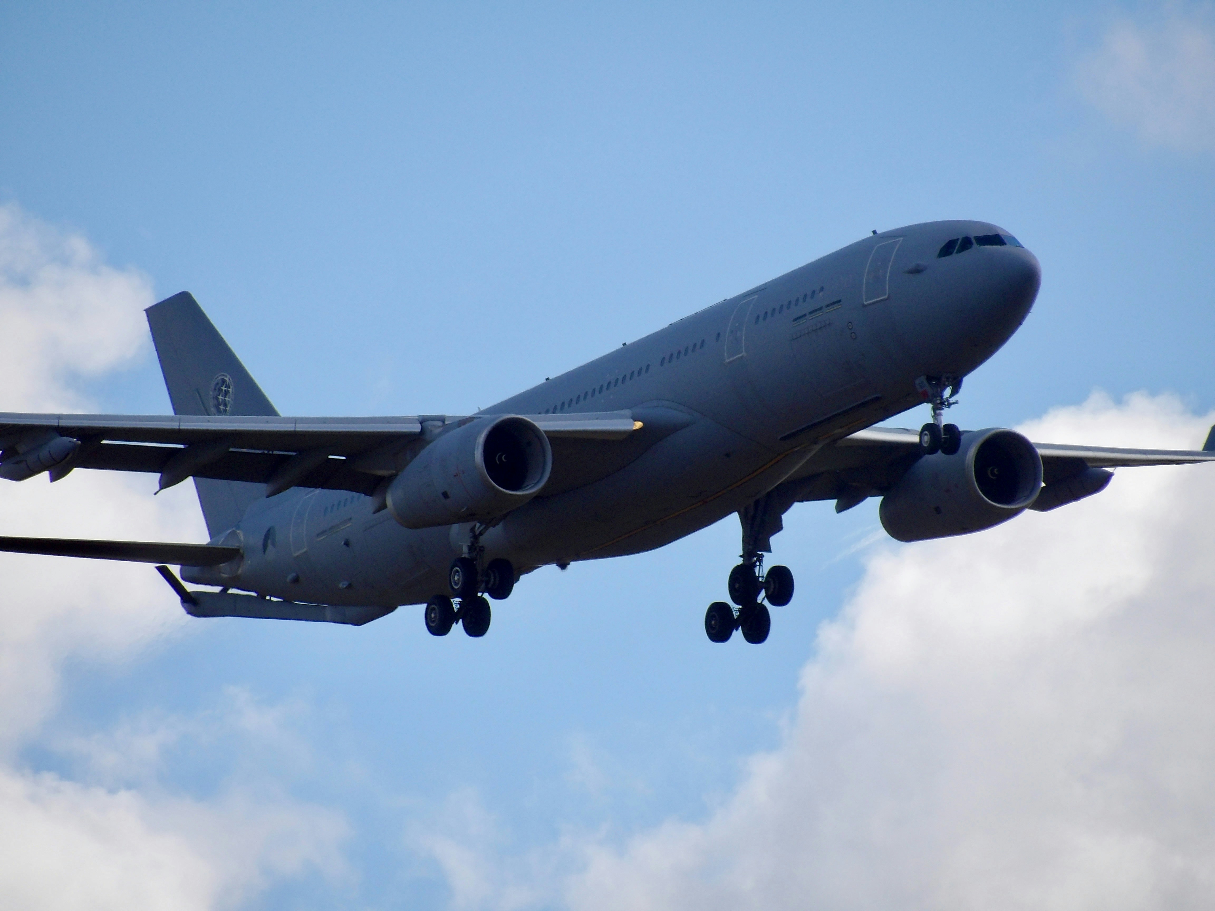 Military aircraft approaching landing against a backdrop of clouds.
