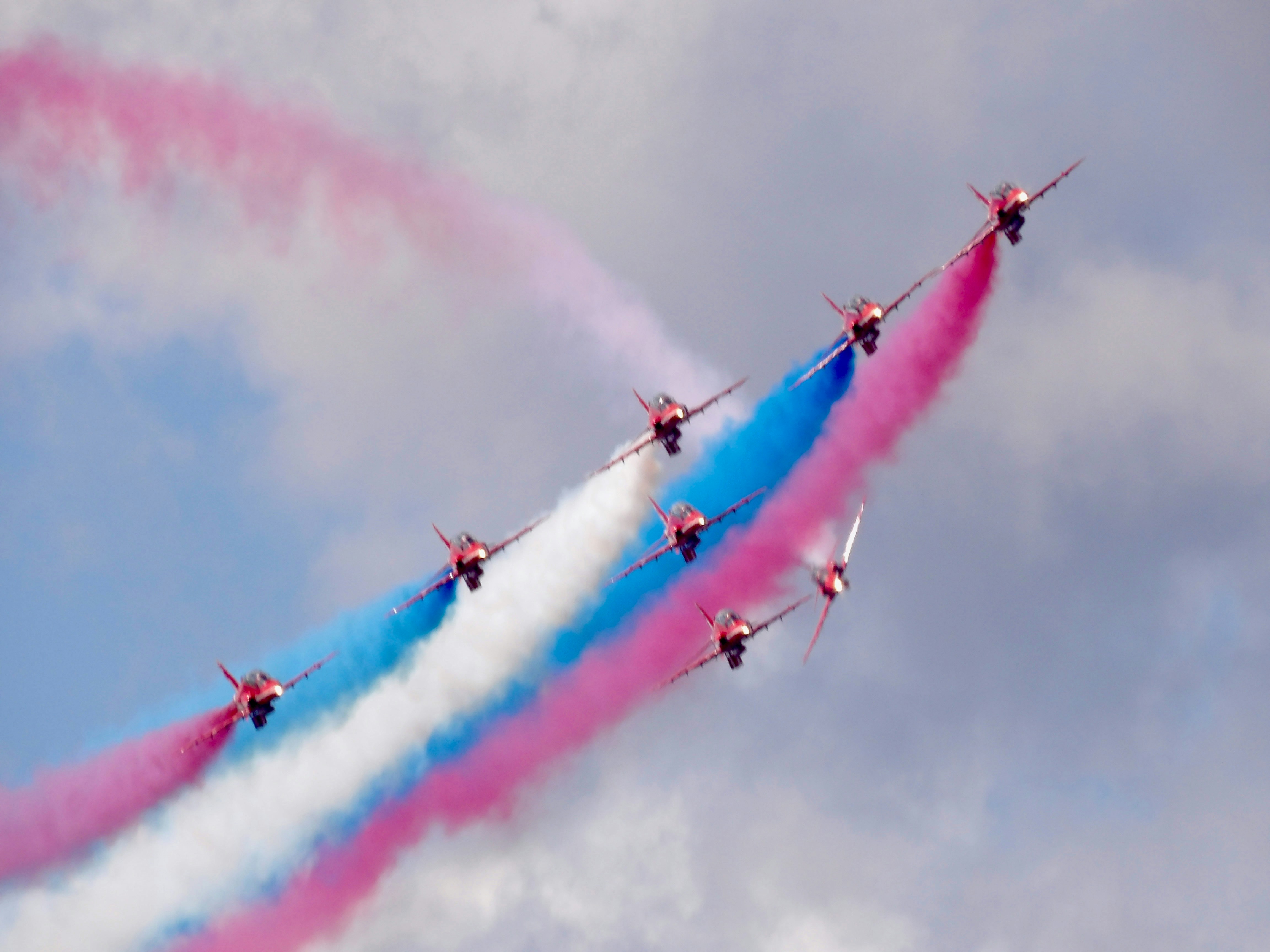 Red arrows display team flying in formation with smoke trails
