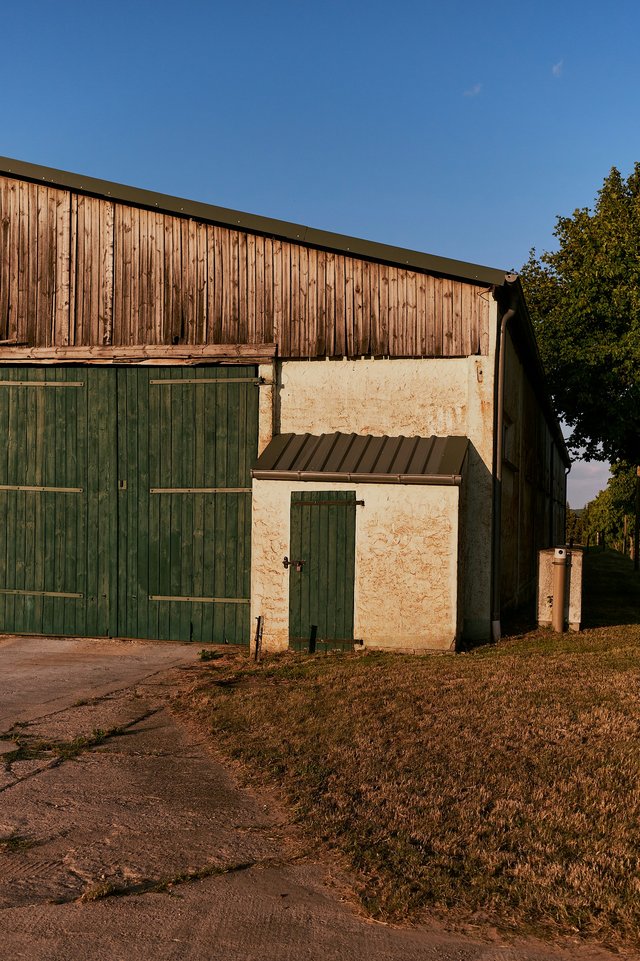 Wooden barn with large green doors and small shed. photo – Free Sunset ...