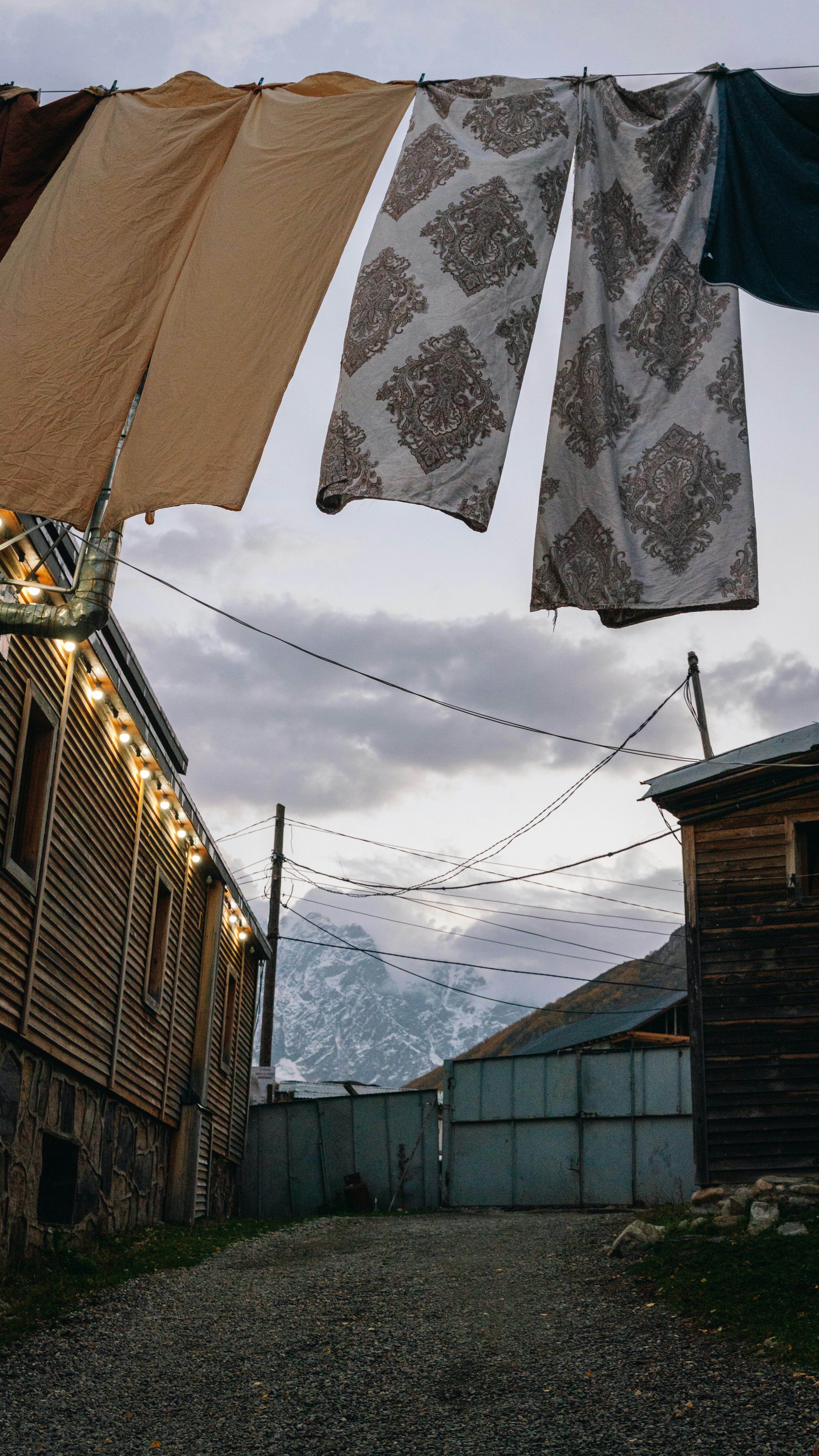 Threads Over the Alley: Laundry Draped Against a Mountain Village Sky