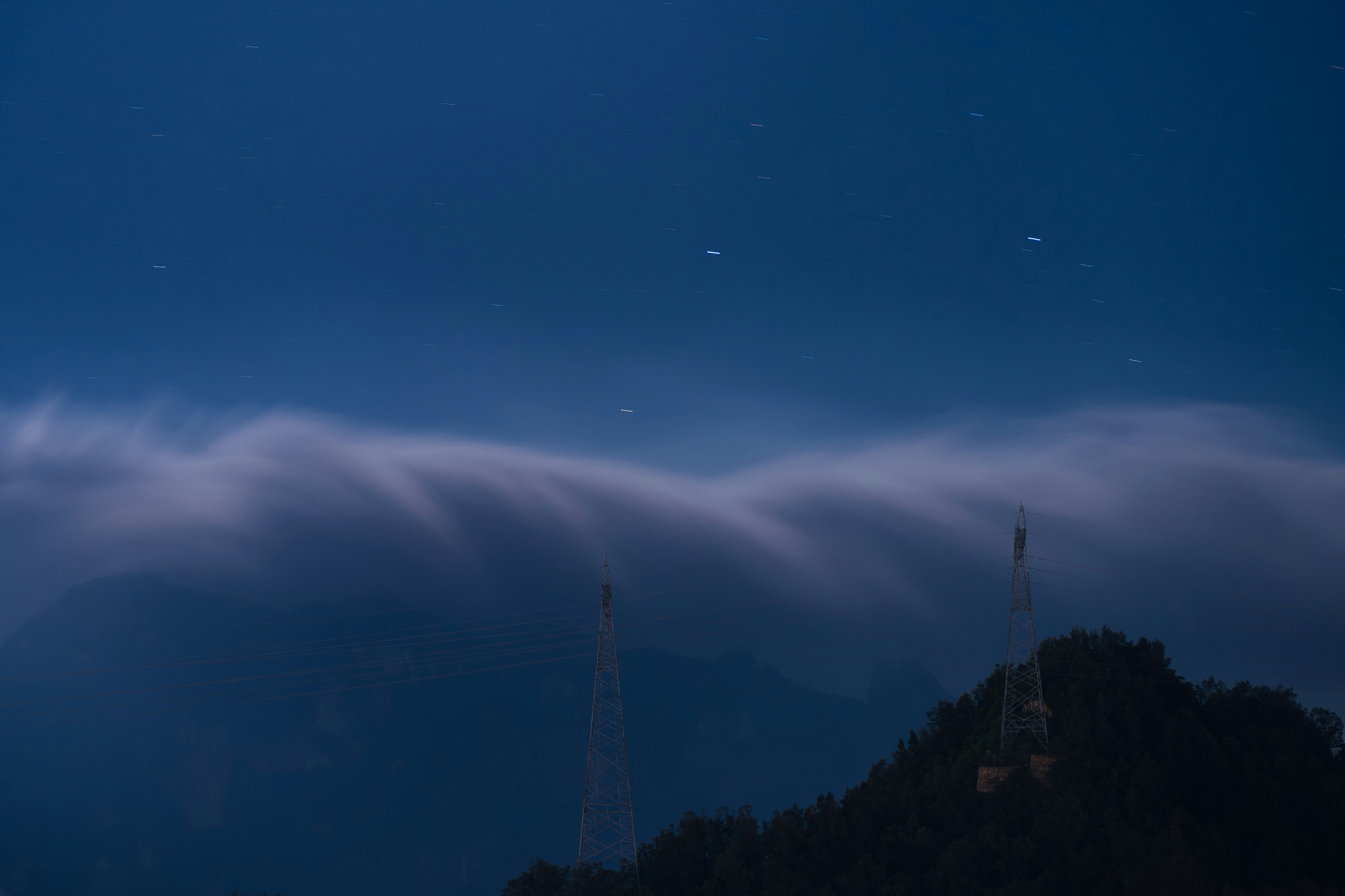 Midnight Ridge: Towers Beneath a Moving Cloud Veil