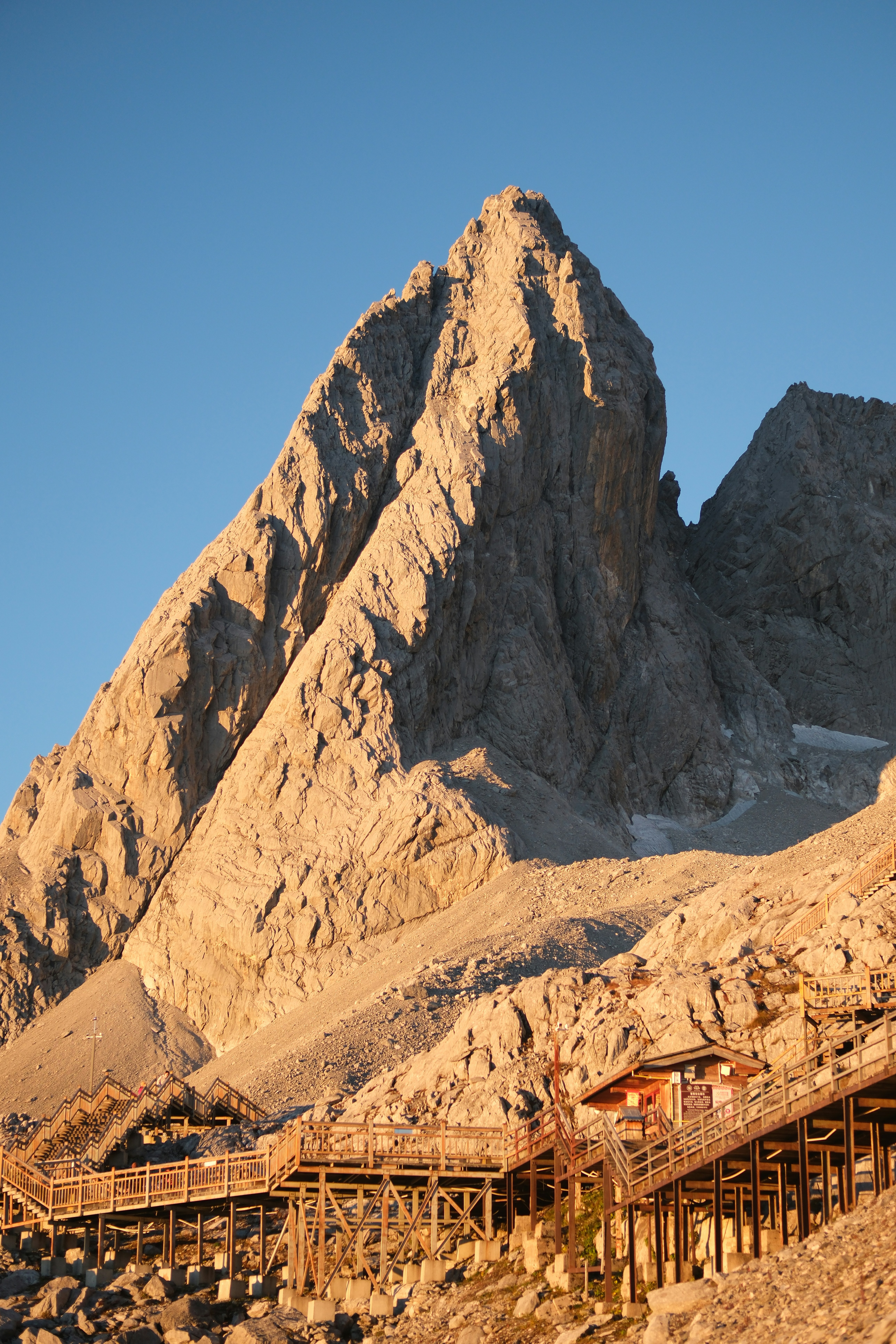 Wooden walkway leads up a rocky mountain slope.