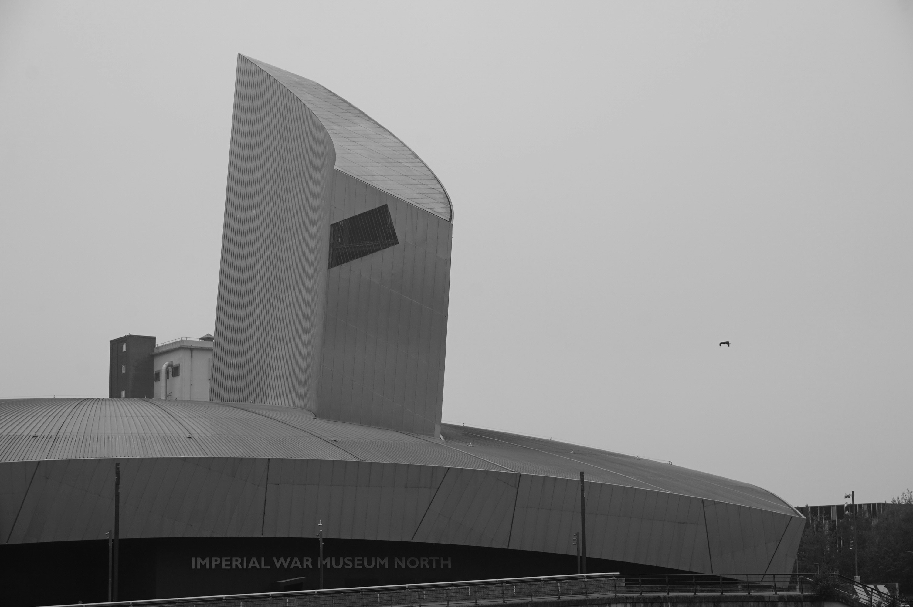 Distinctive metallic structure of the Imperial War Museum North, showcasing its unique design against a muted sky.