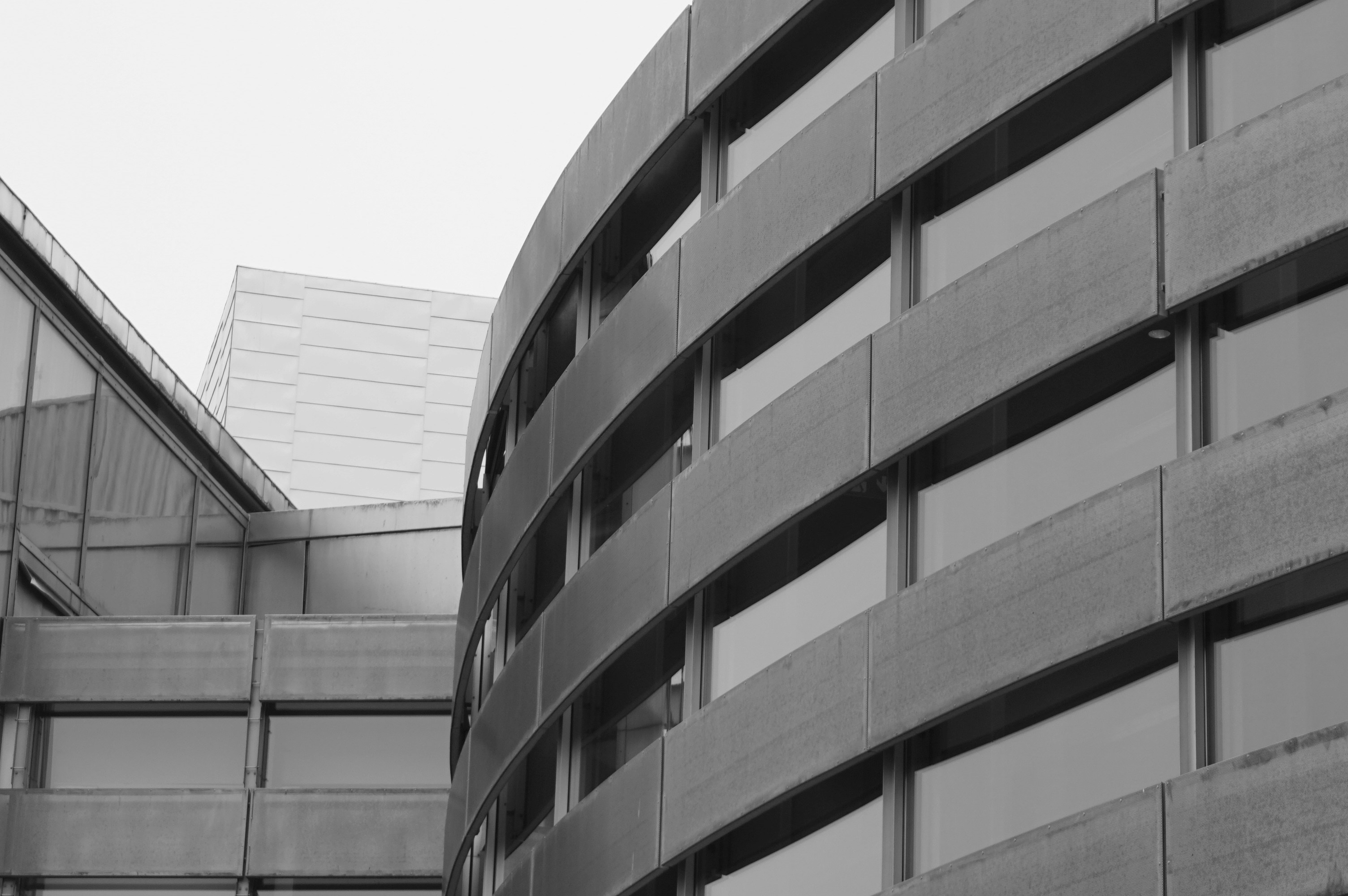 Curved modern building facade with reflective windows.