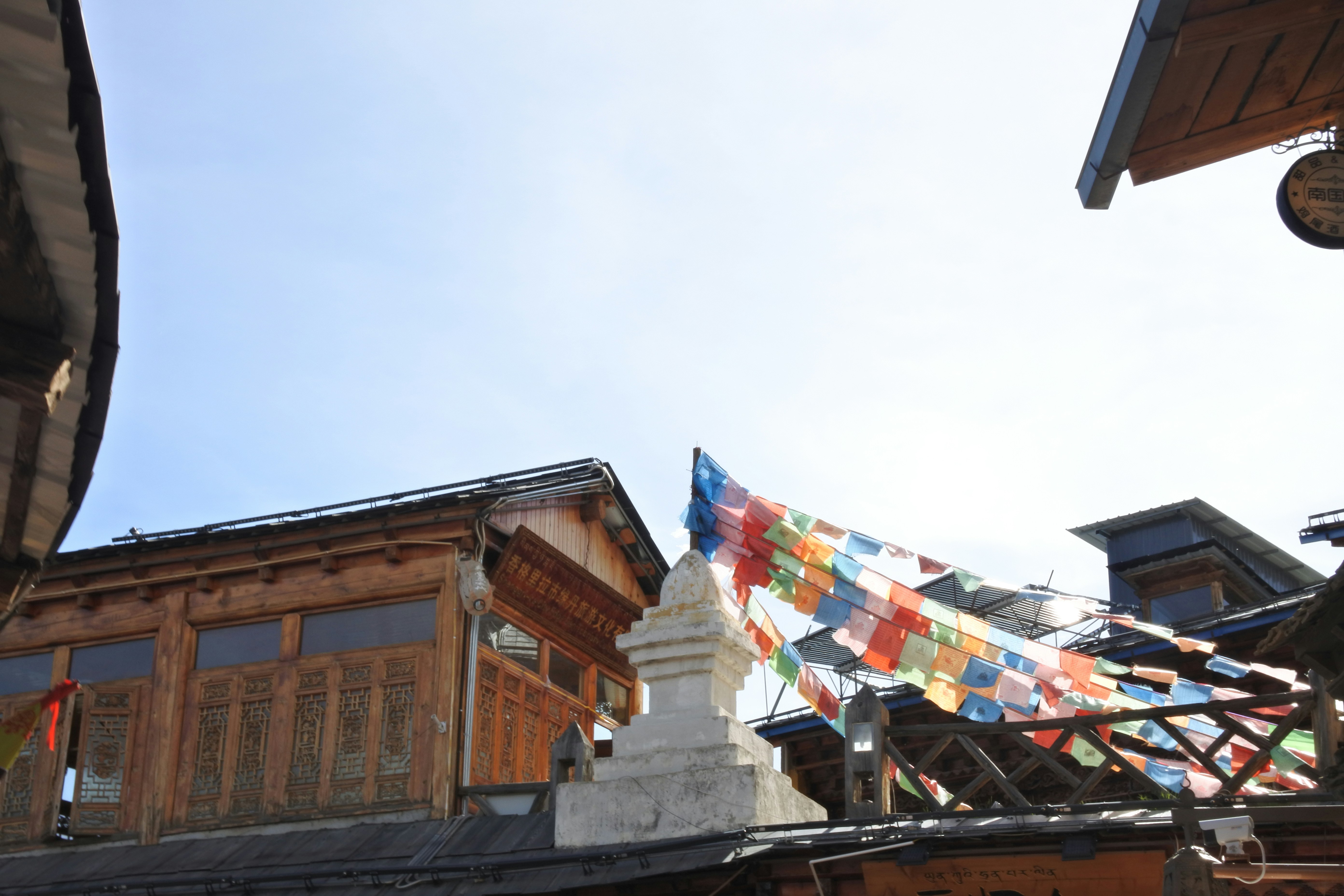 Colorful prayer flags adorn traditional wooden buildings.