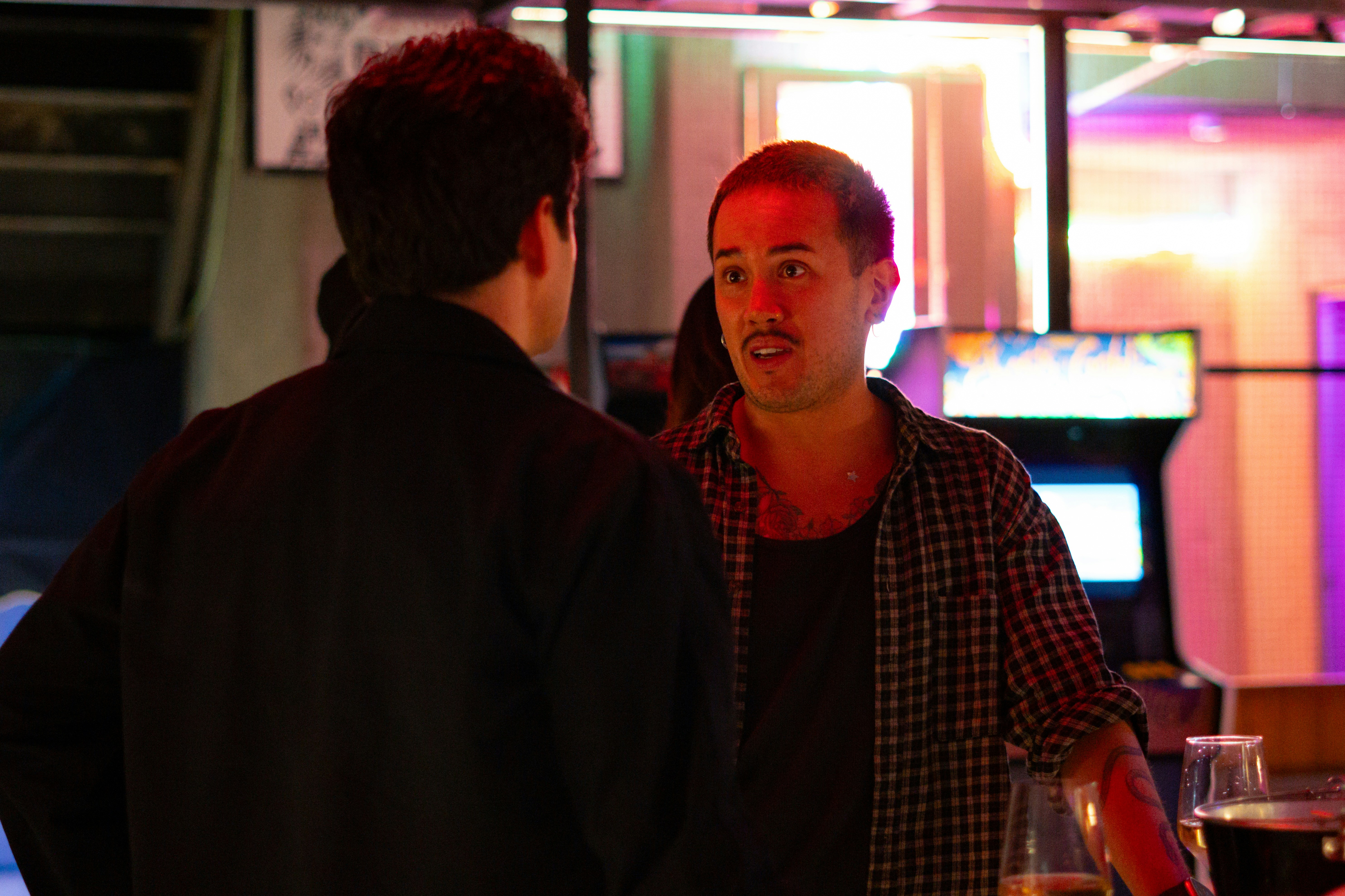 Two men talking in a dimly lit bar