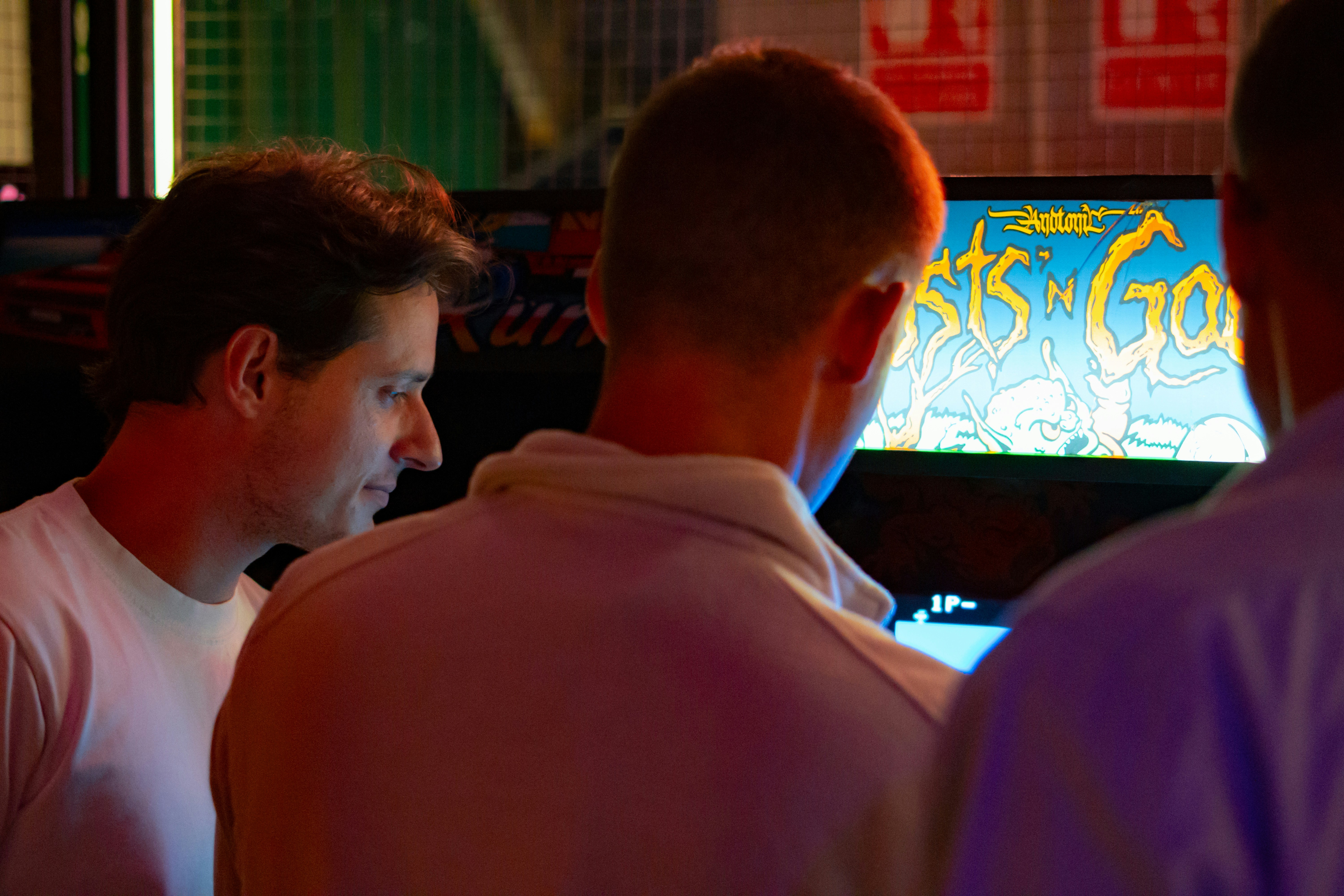 Three men looking at a video game screen