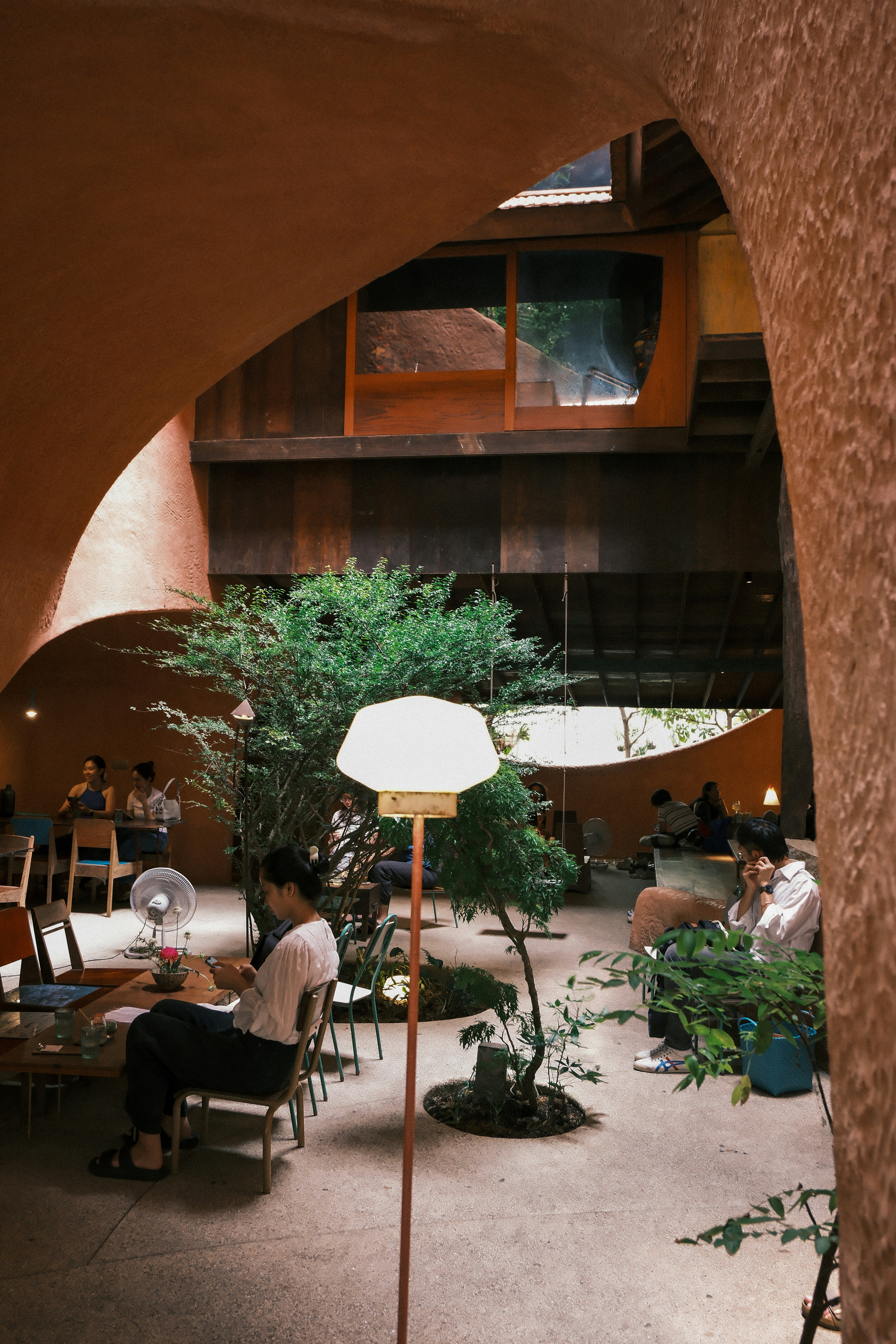 People relaxing in a cozy cafe with indoor plants