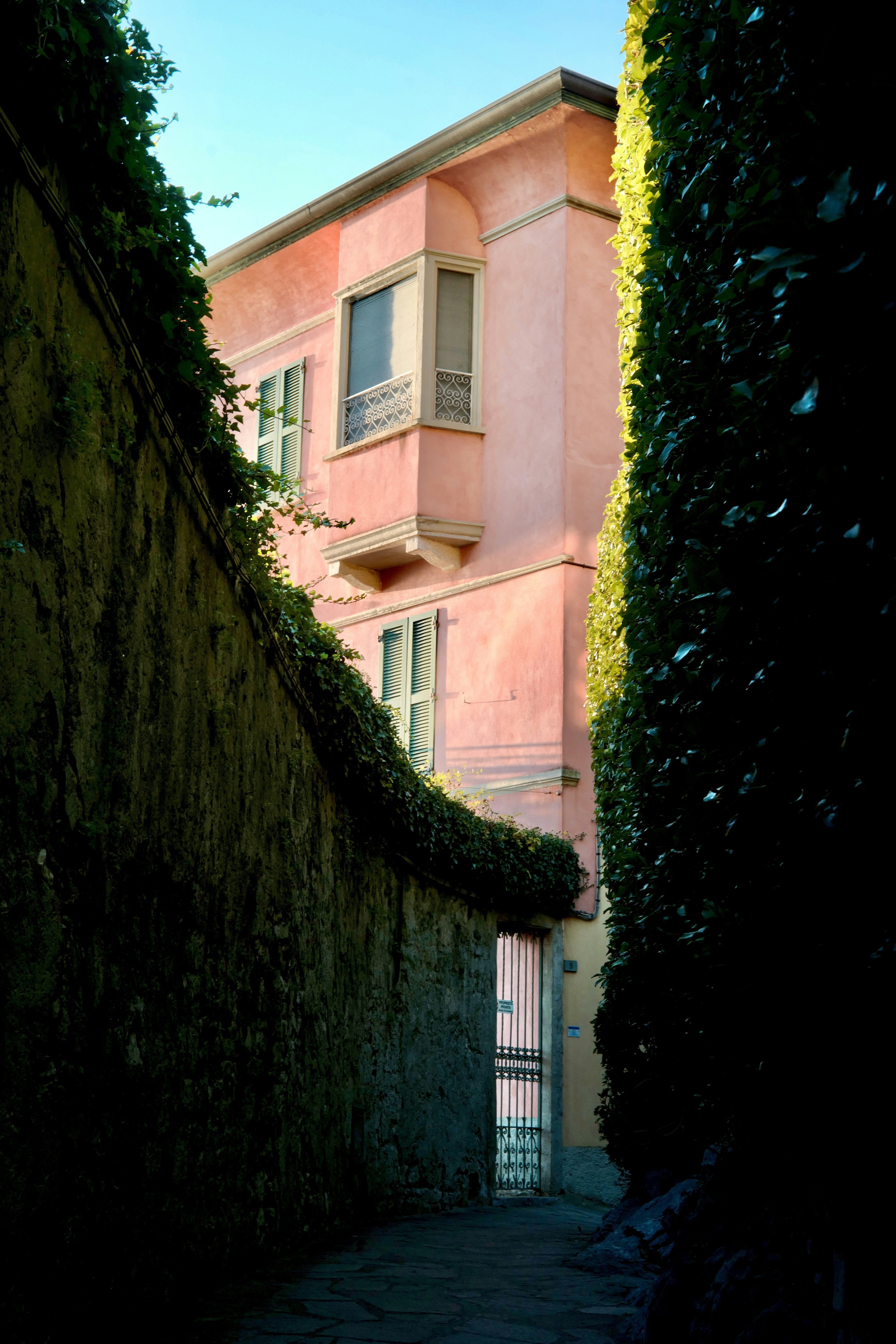Pink building with ivy covered walls and gate