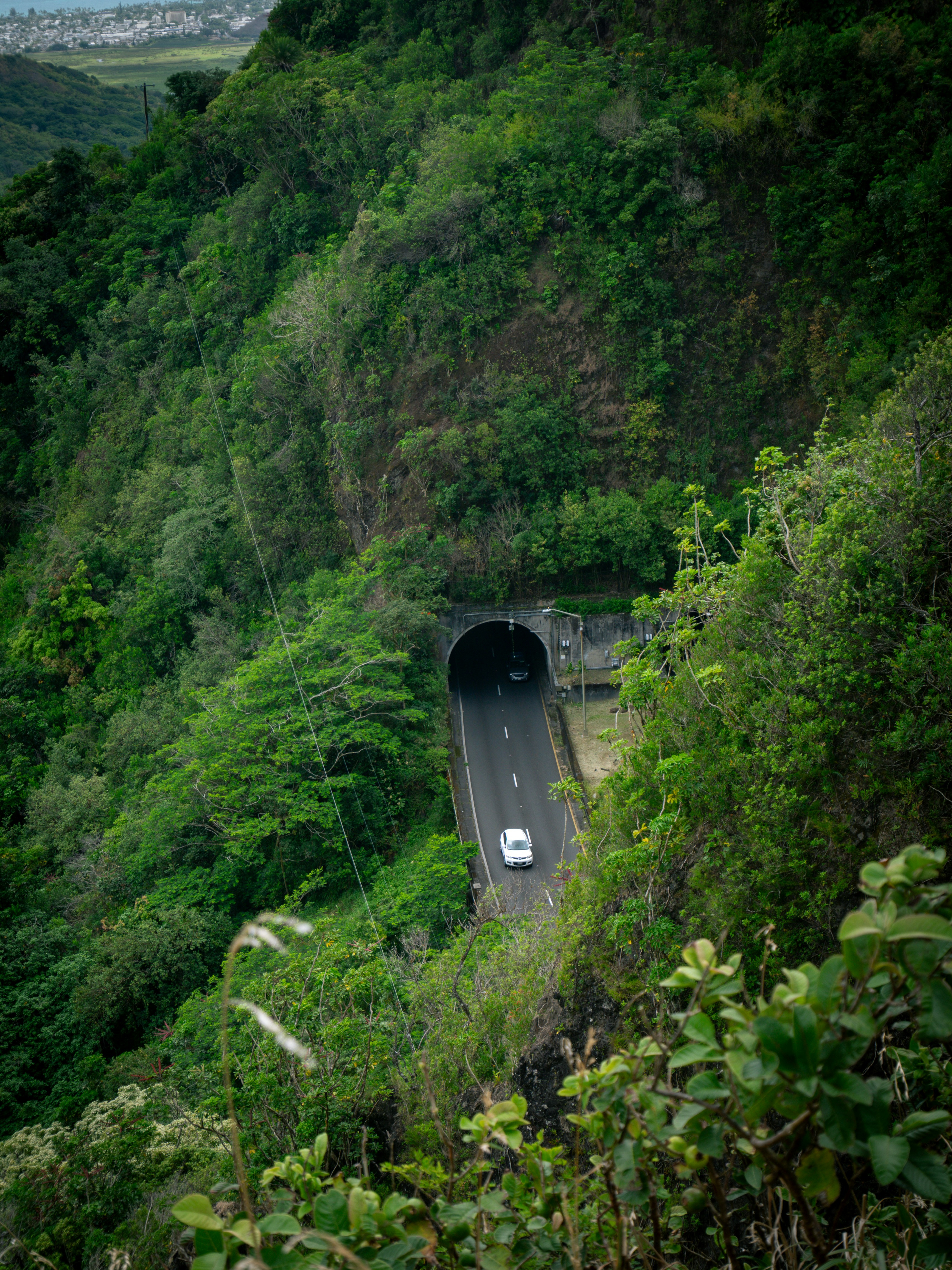 Car driving towards a tunnel on a mountain road