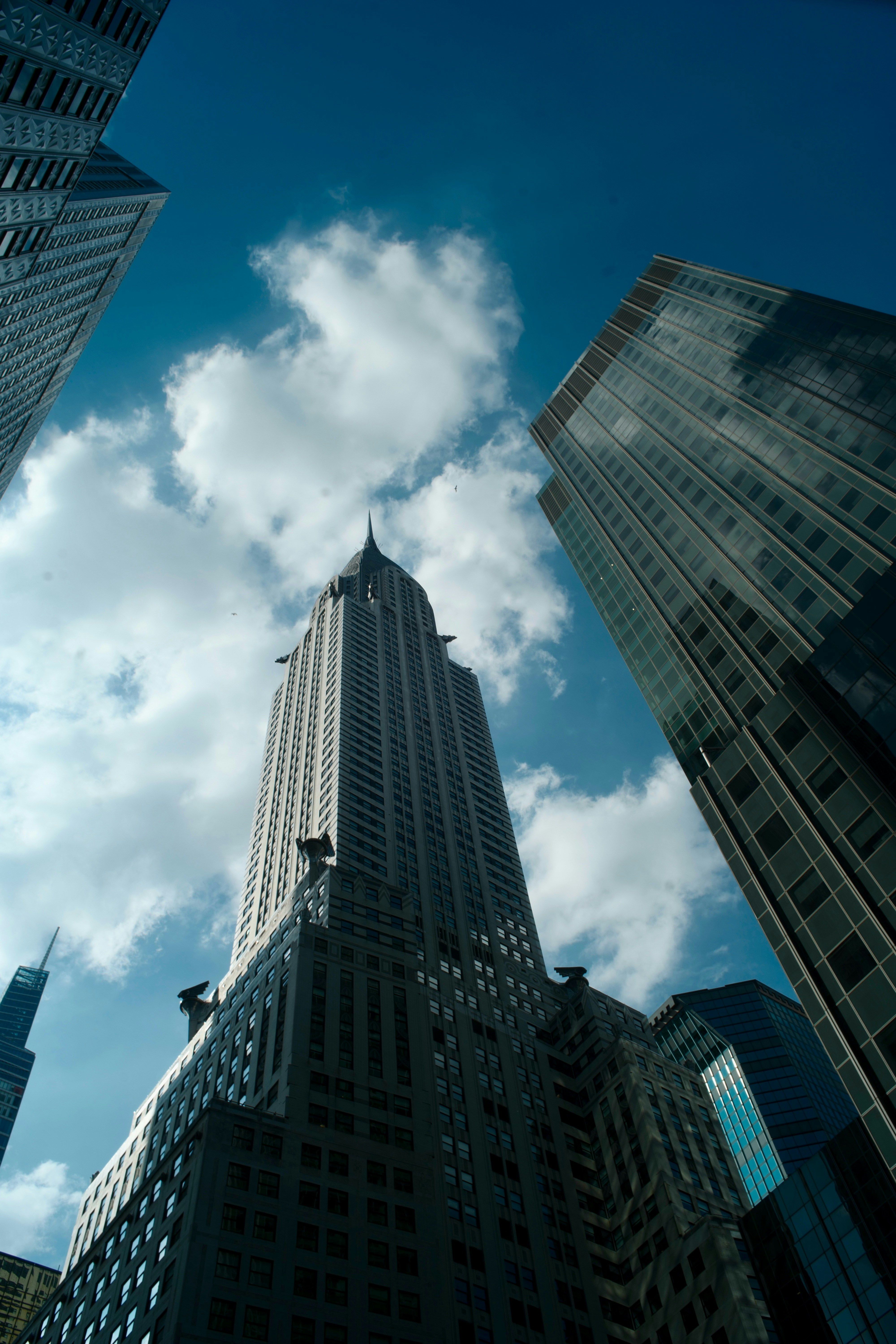 Skyscrapers reaching towards a cloudy blue sky