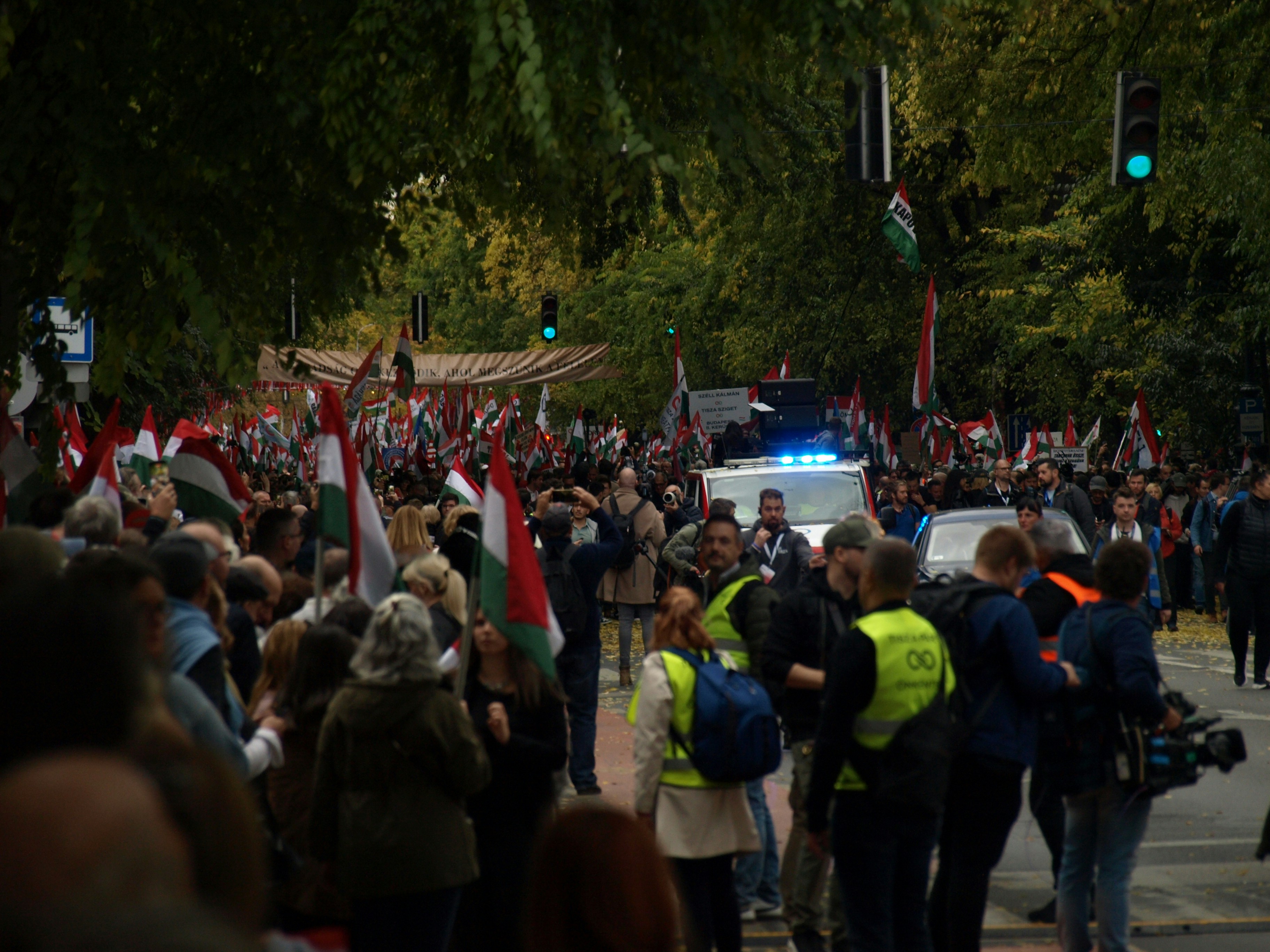 October 23, commemorating the 1956 Hungarian Revolution | Crowd of people waving hungarian flags near police car