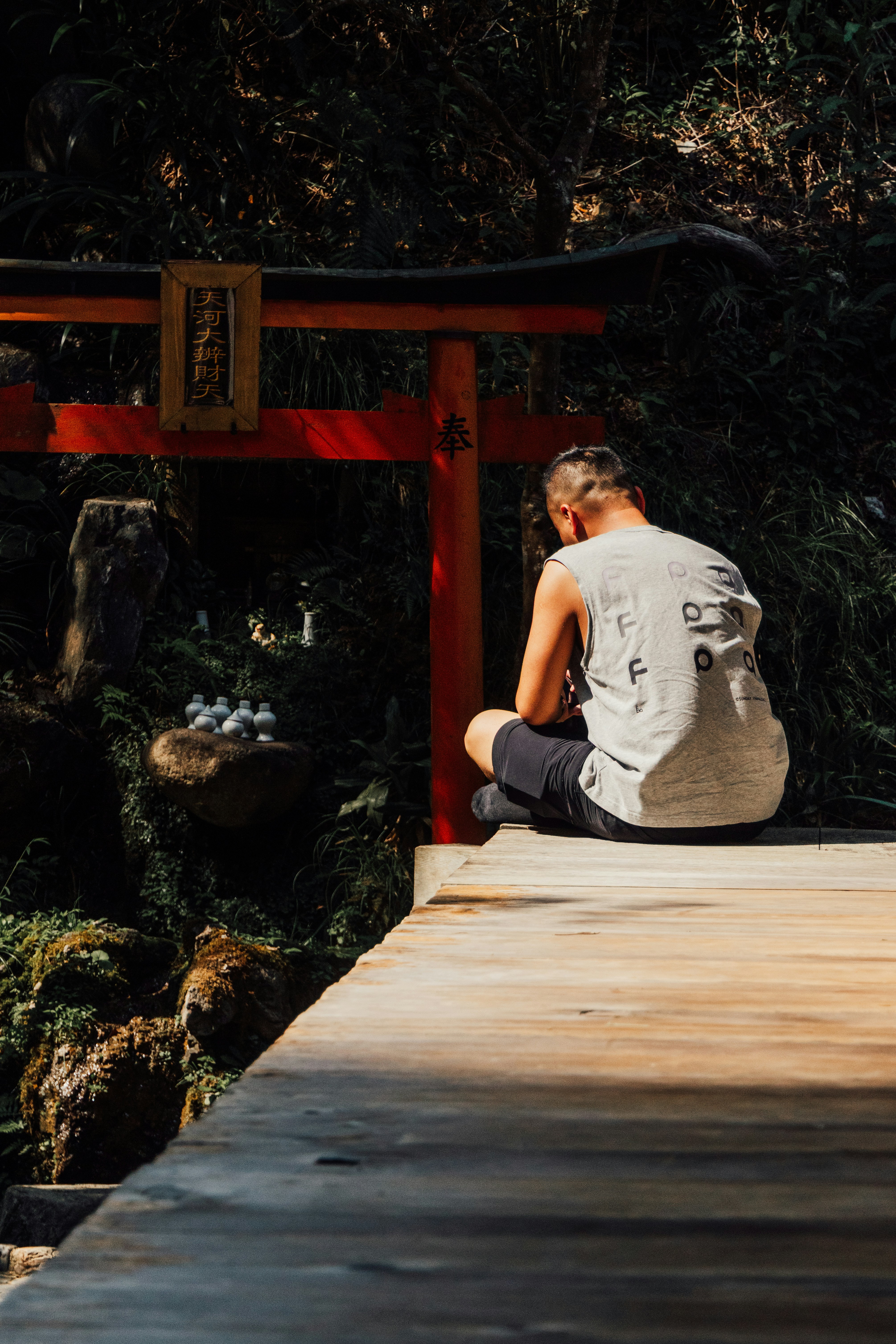 Contemplation at the Crimson Gate: A lone figure on a wooden bridge
