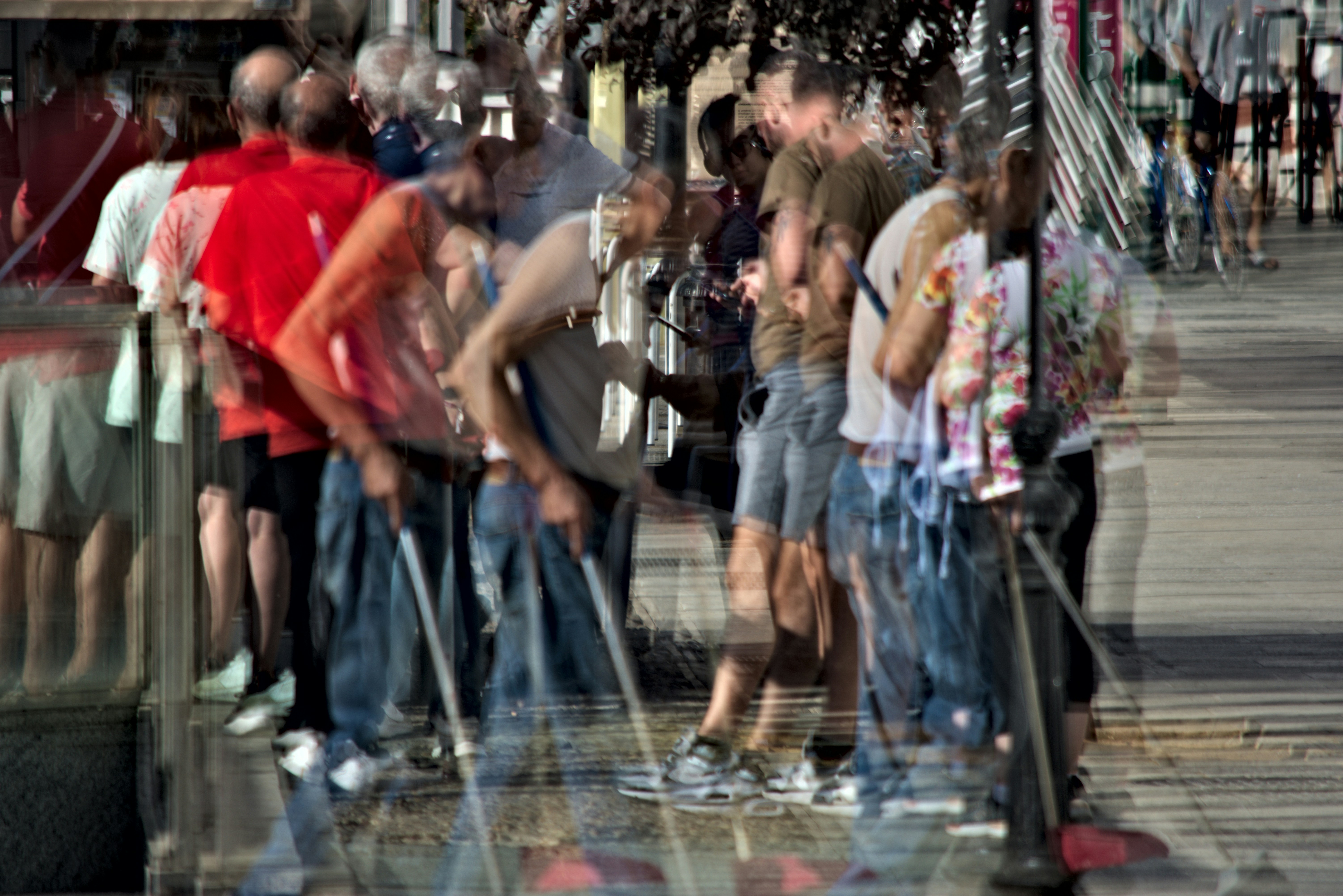 A blurred scene capturing a group of people engaged in conversation, illustrating the hustle of urban life. The dynamic motion adds a sense of energy to the composition.