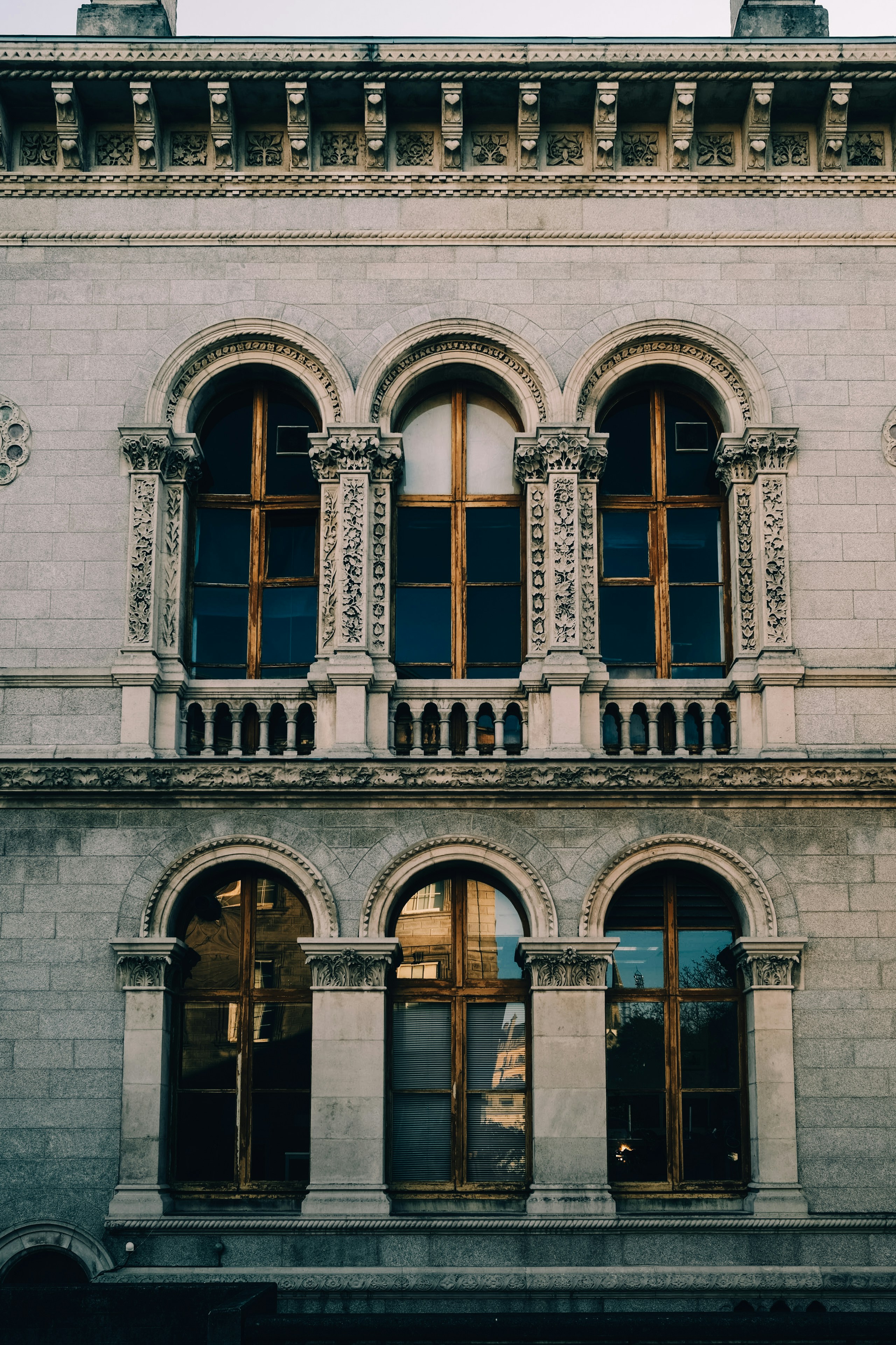 Intricately designed stone facade showcasing arched windows and ornate detailing, reflecting a rich architectural heritage.