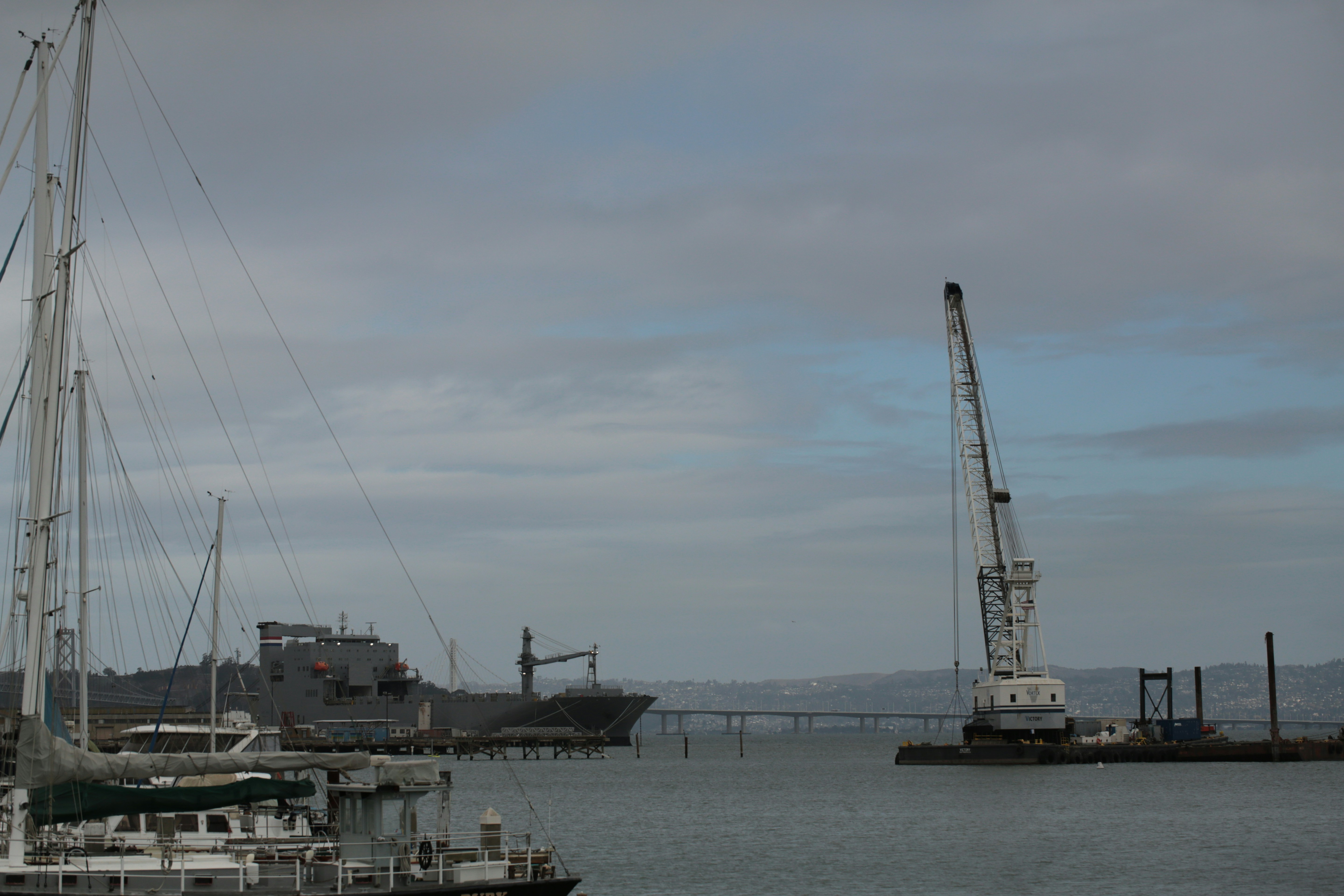 Crane Over a Quiet Harbor: Lines of Sails Meet Steel
