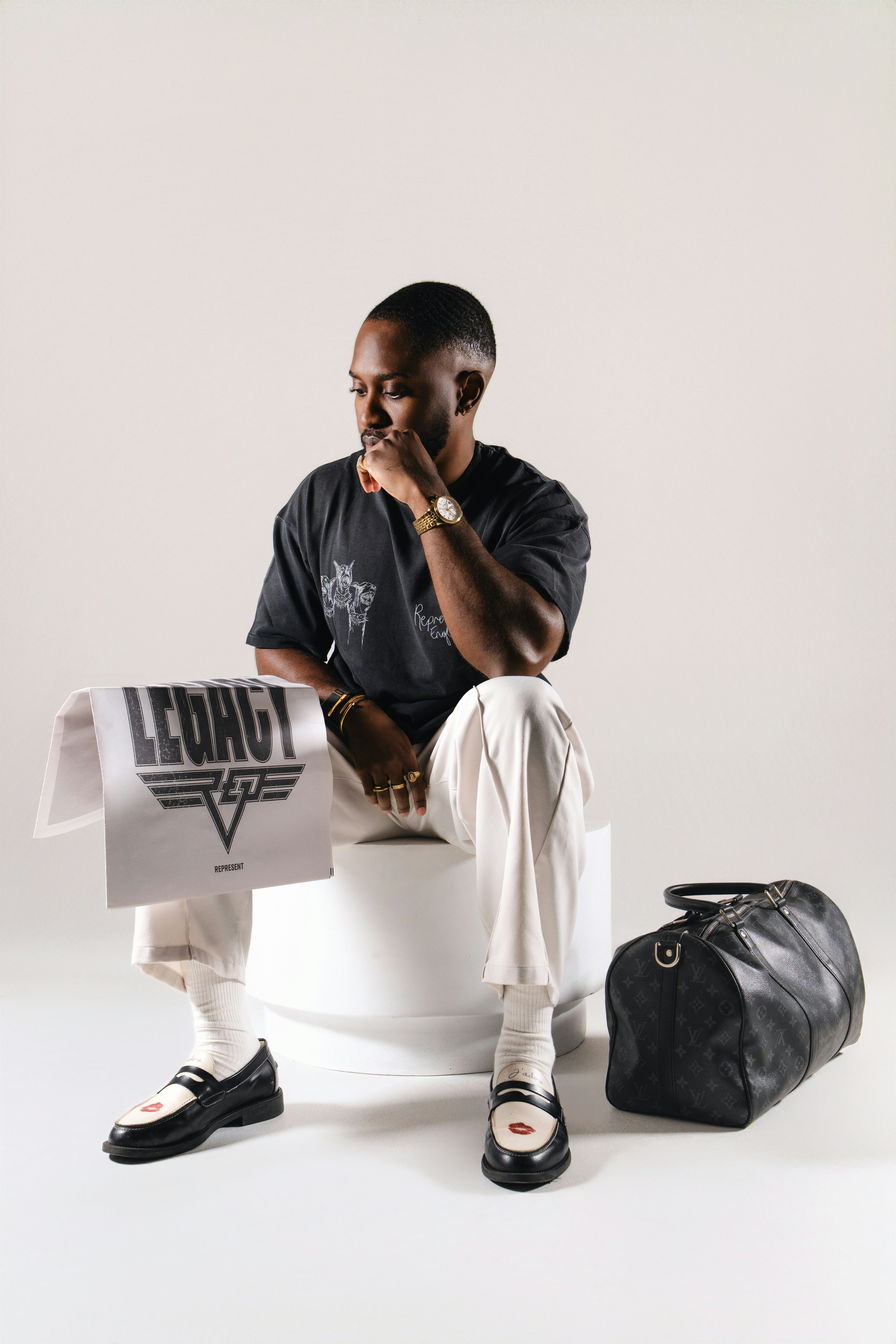 Man in stylish outfit holding a towel with logo.