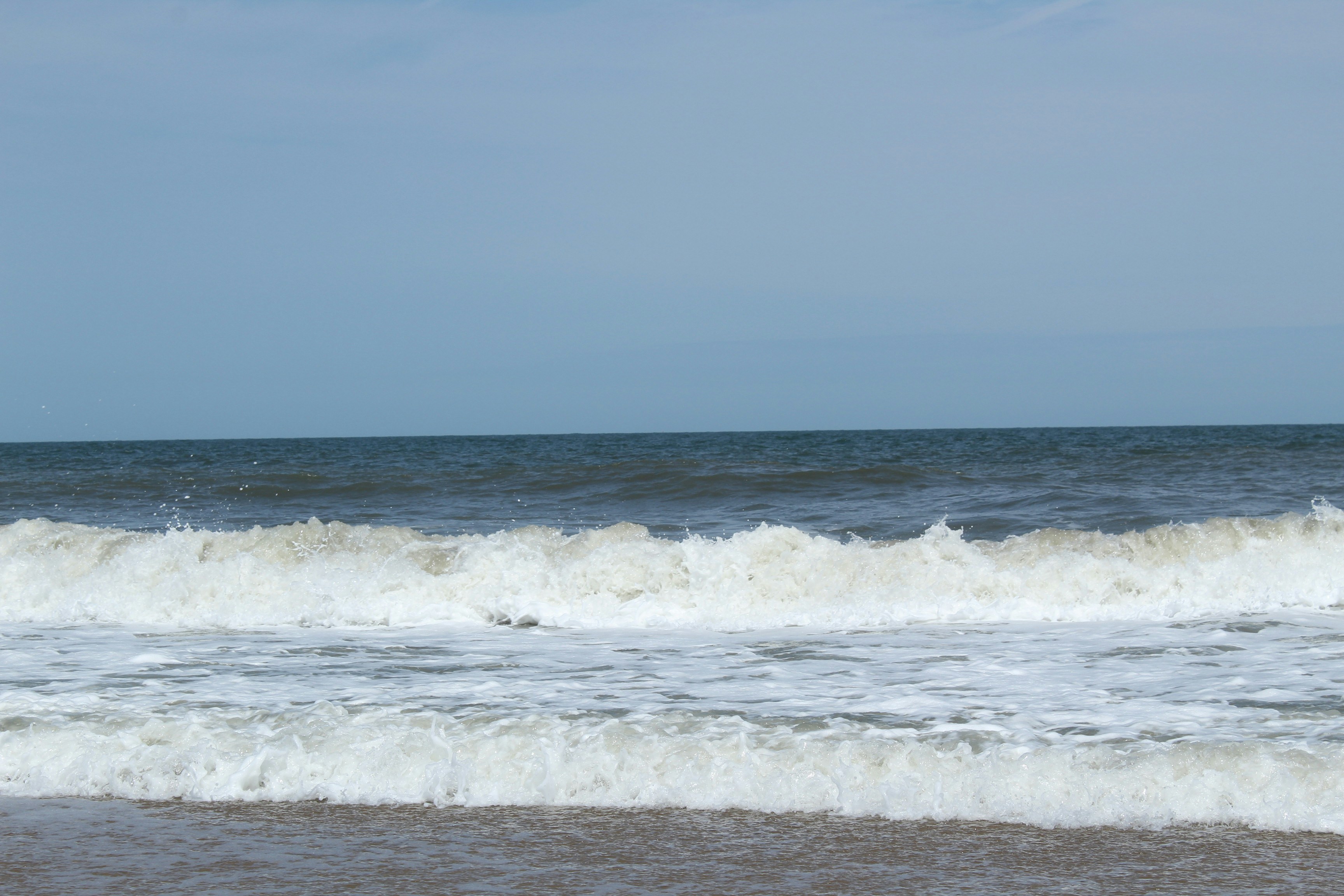 Ocean waves crashing on a sandy beach.