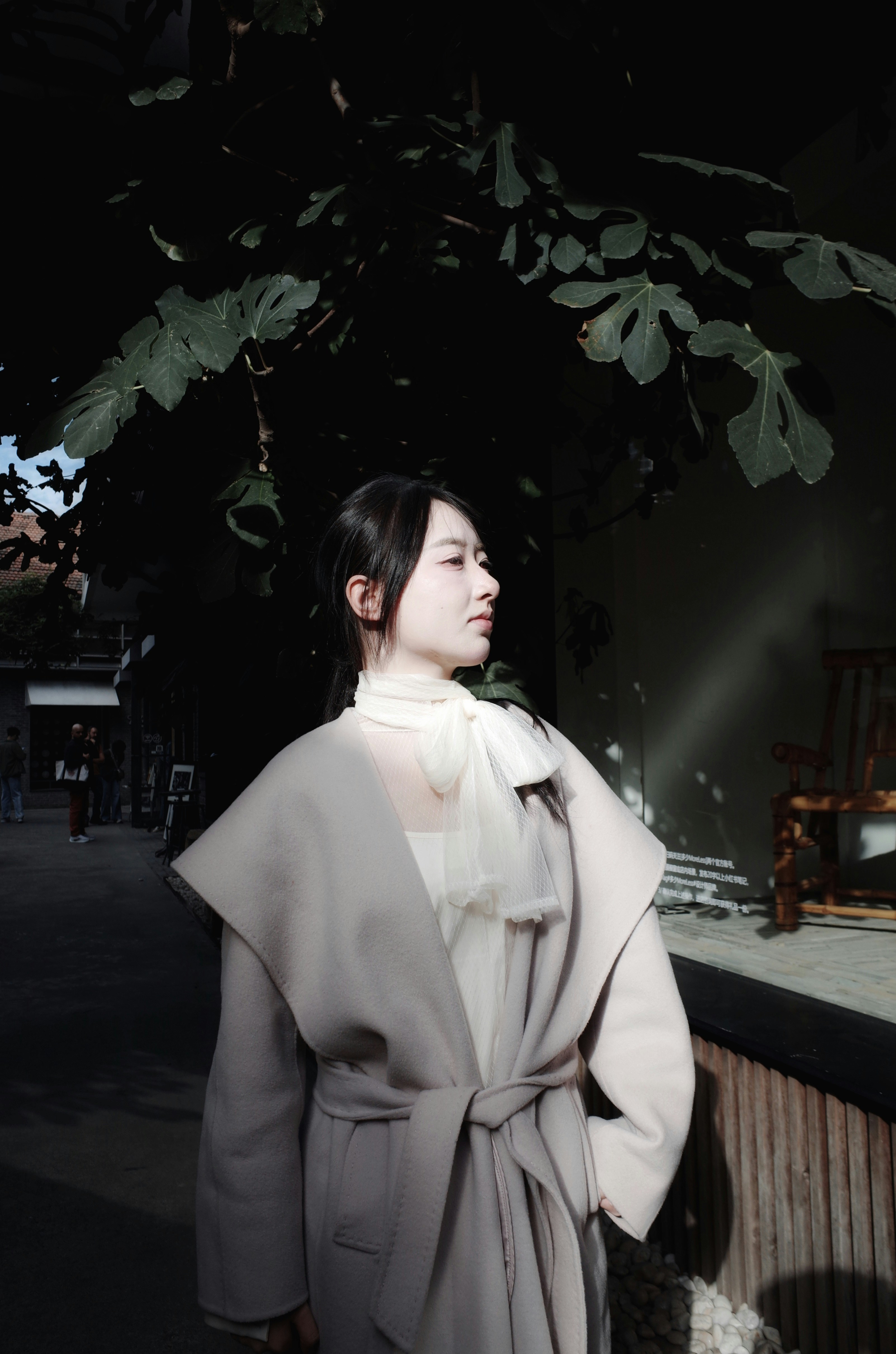 Woman in a light coat standing outdoors