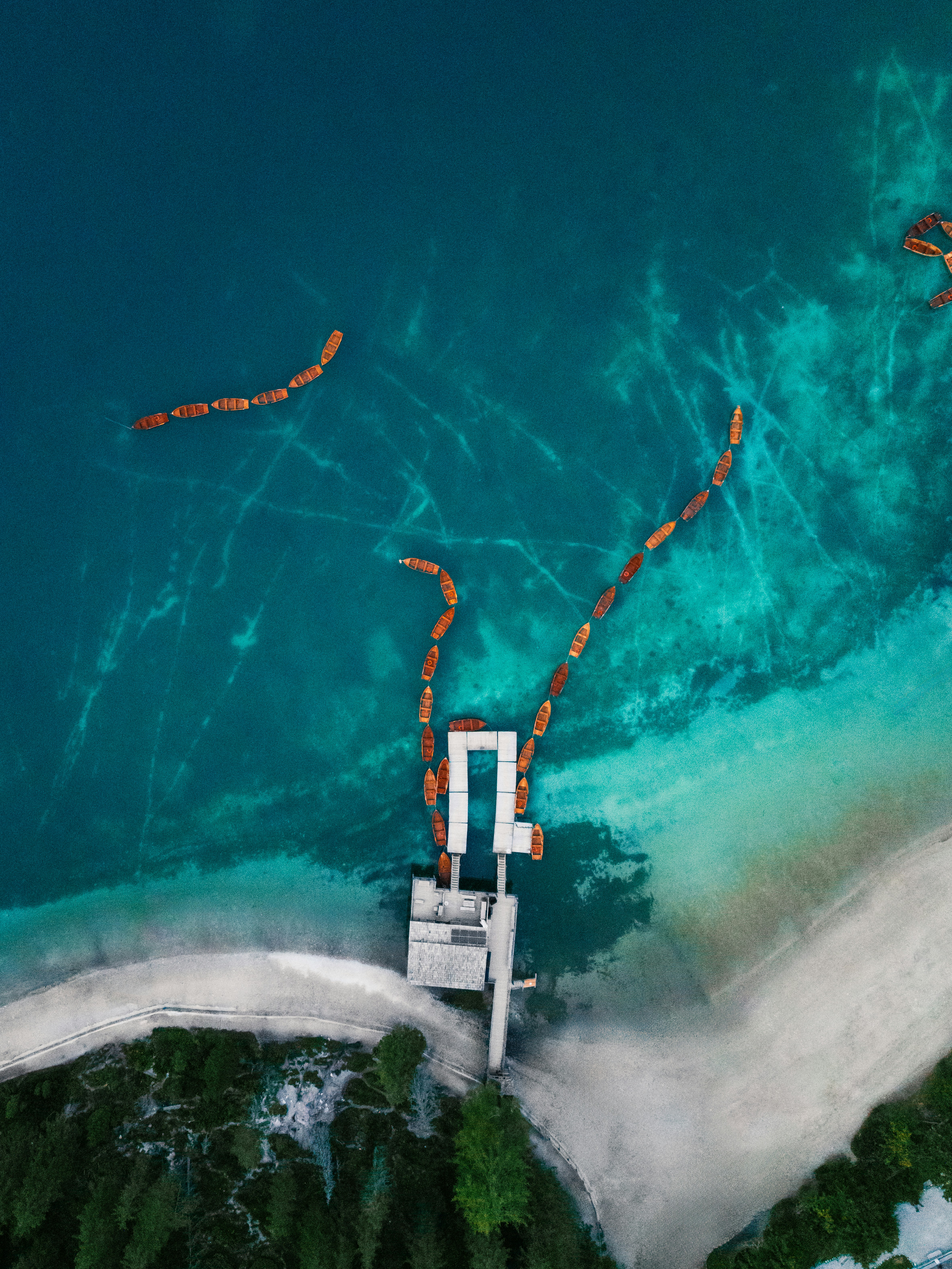 Jetée en bois avec des bateaux sur un lac turquoise photo – Image ...