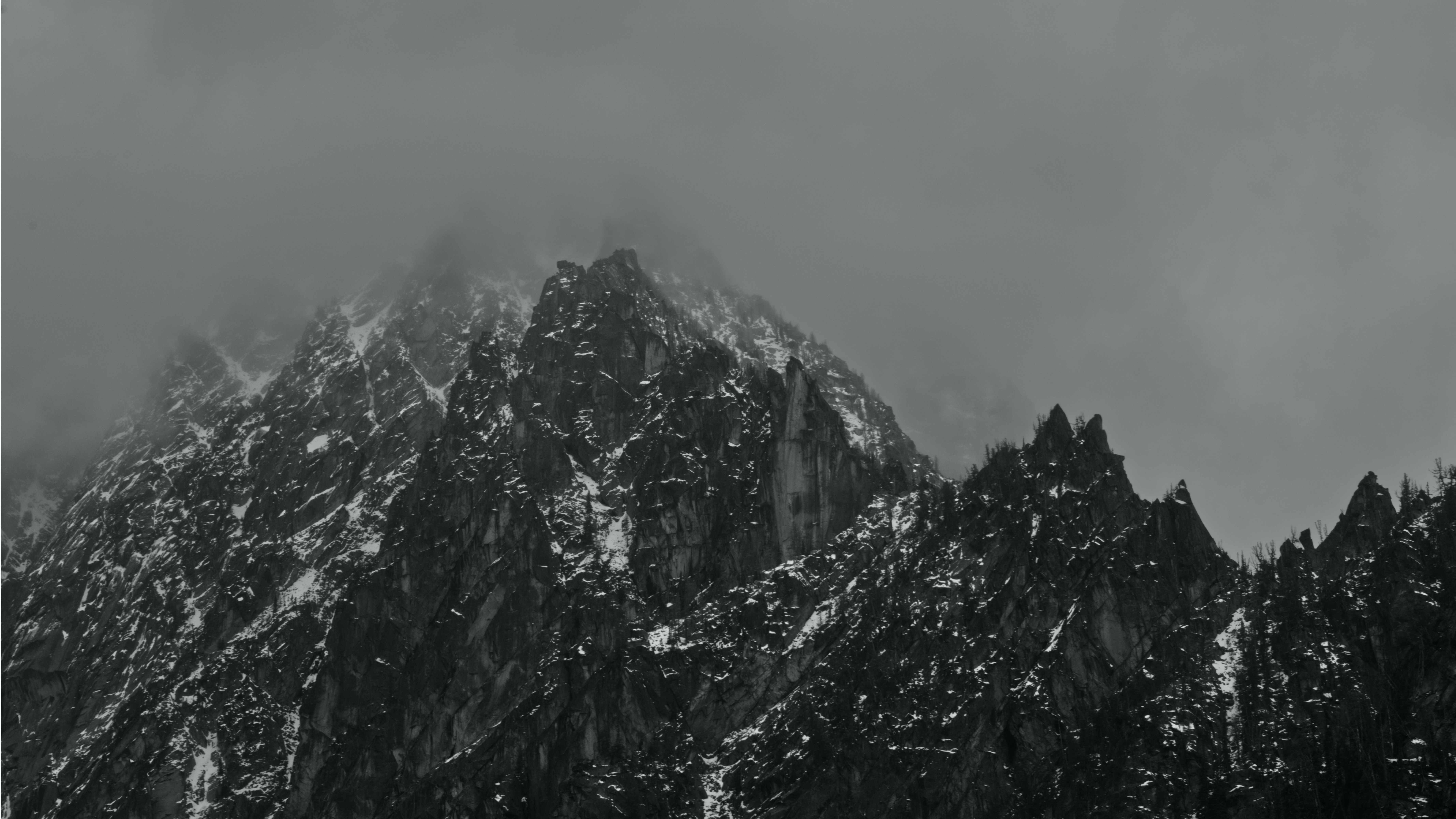 Snow-covered mountain peaks shrouded in mist