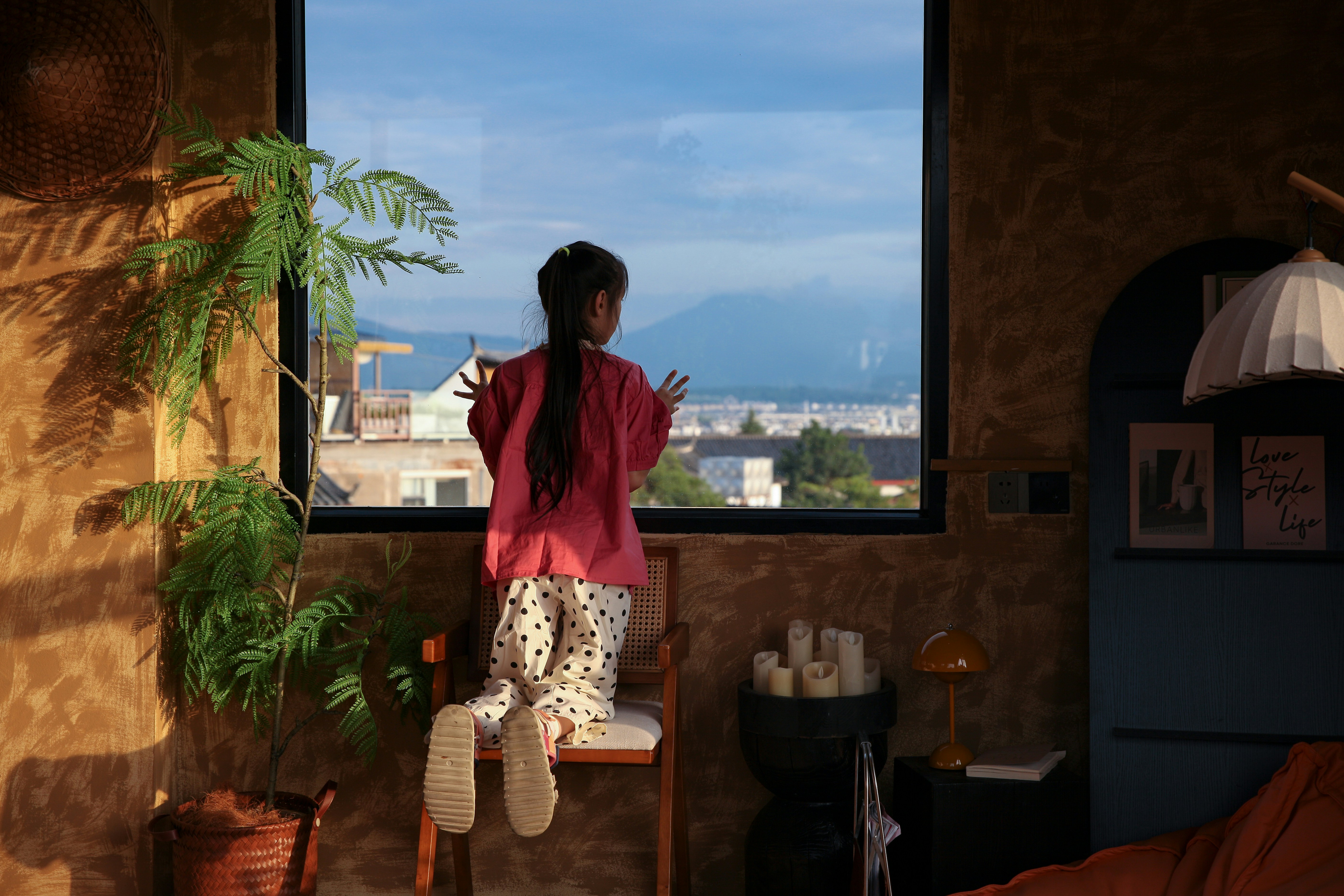 Woman looking out window at mountains and sky