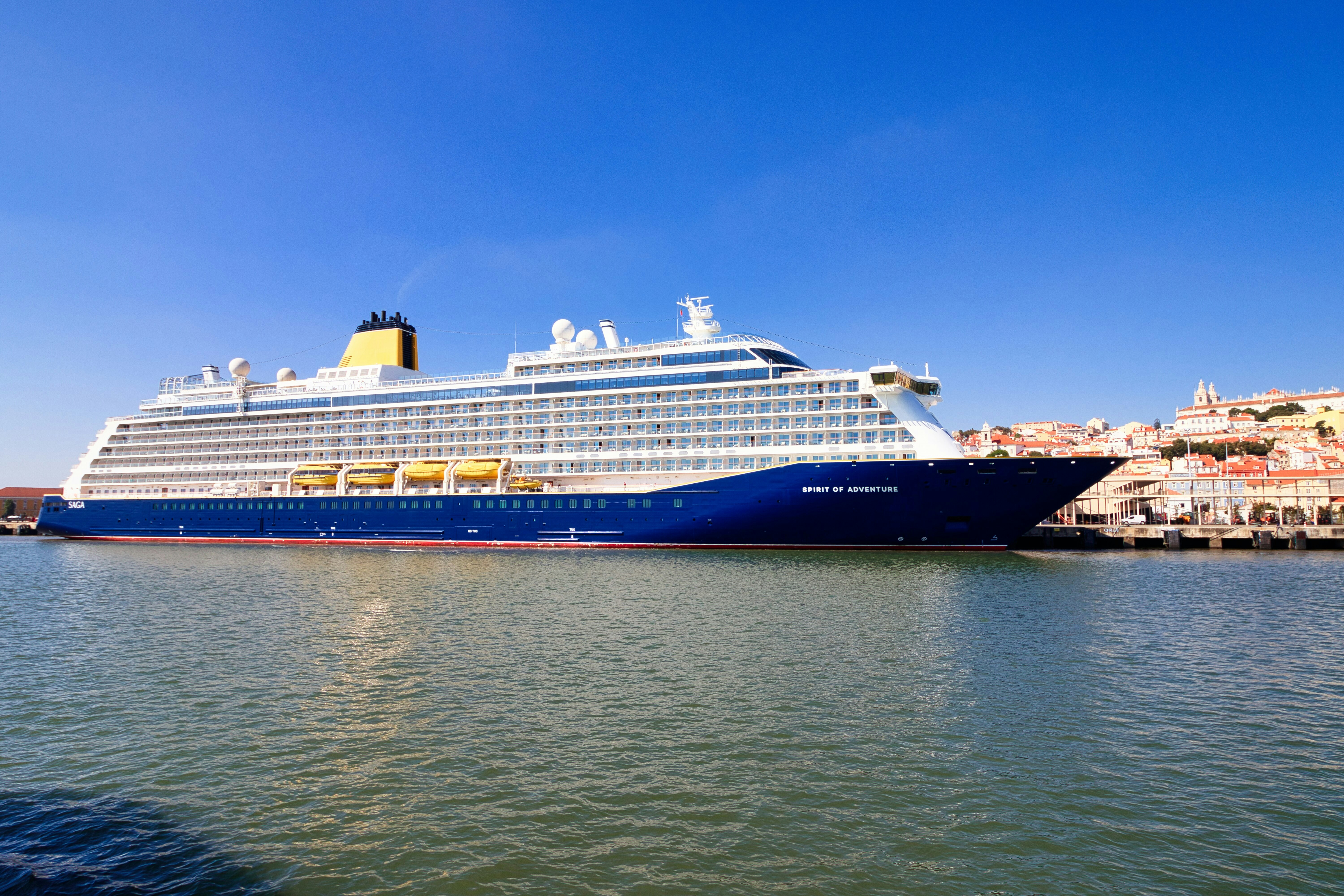 Cruise ship | A large blue cruise ship docked in a harbor.