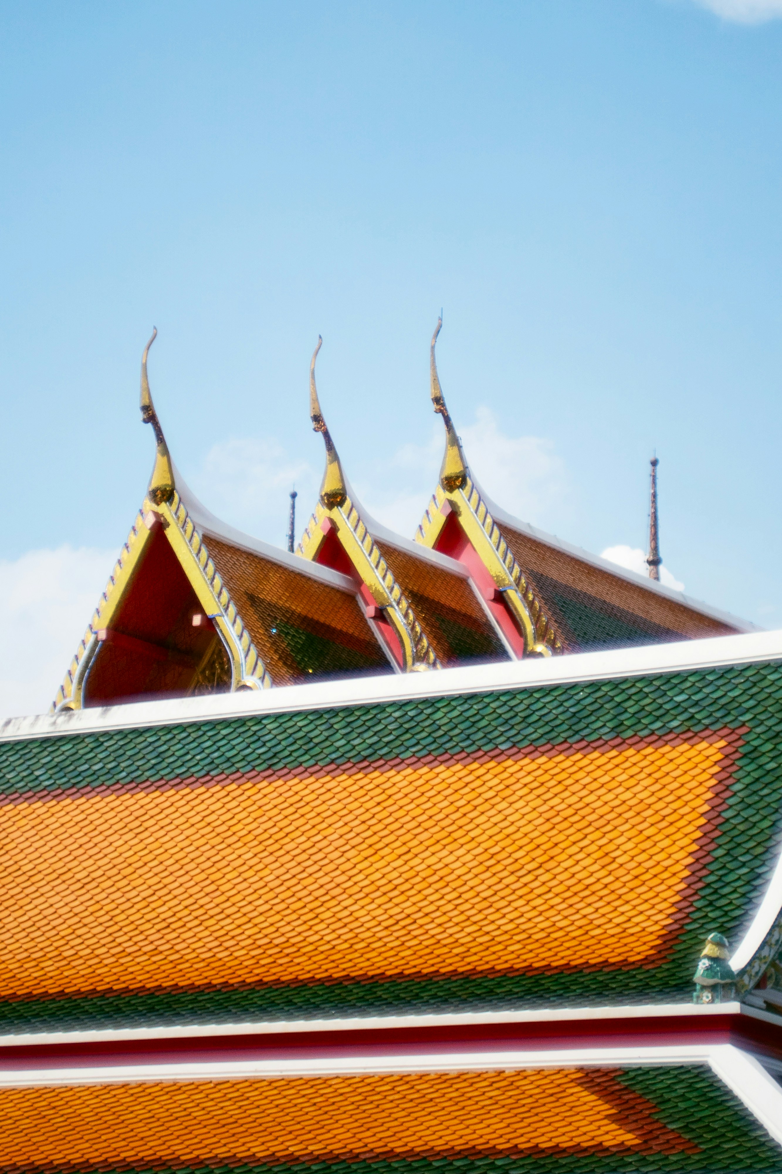 Three ornate temple roofs under a blue sky