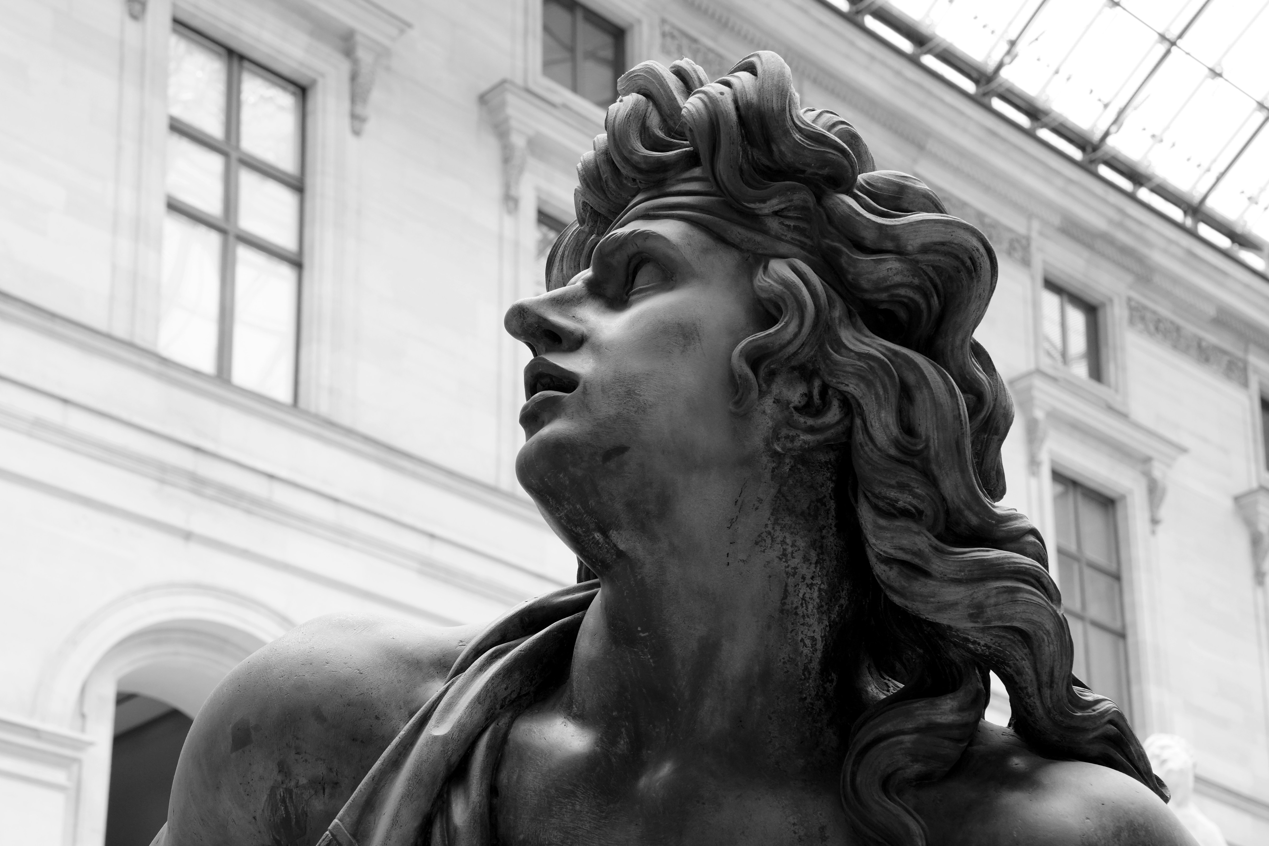 A black and white close-up of a statue's head.