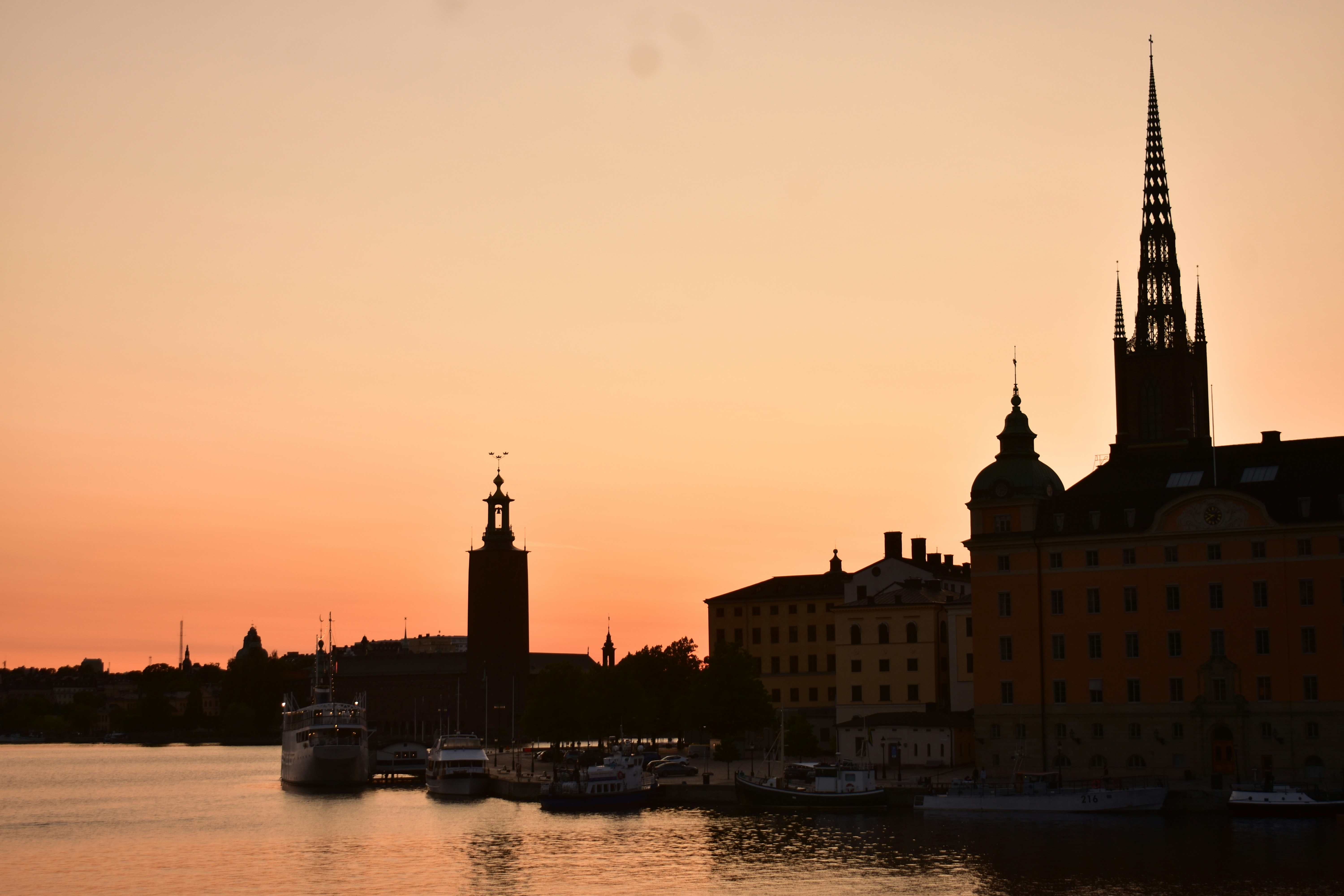City skyline silhouetted against an orange sunset sky.