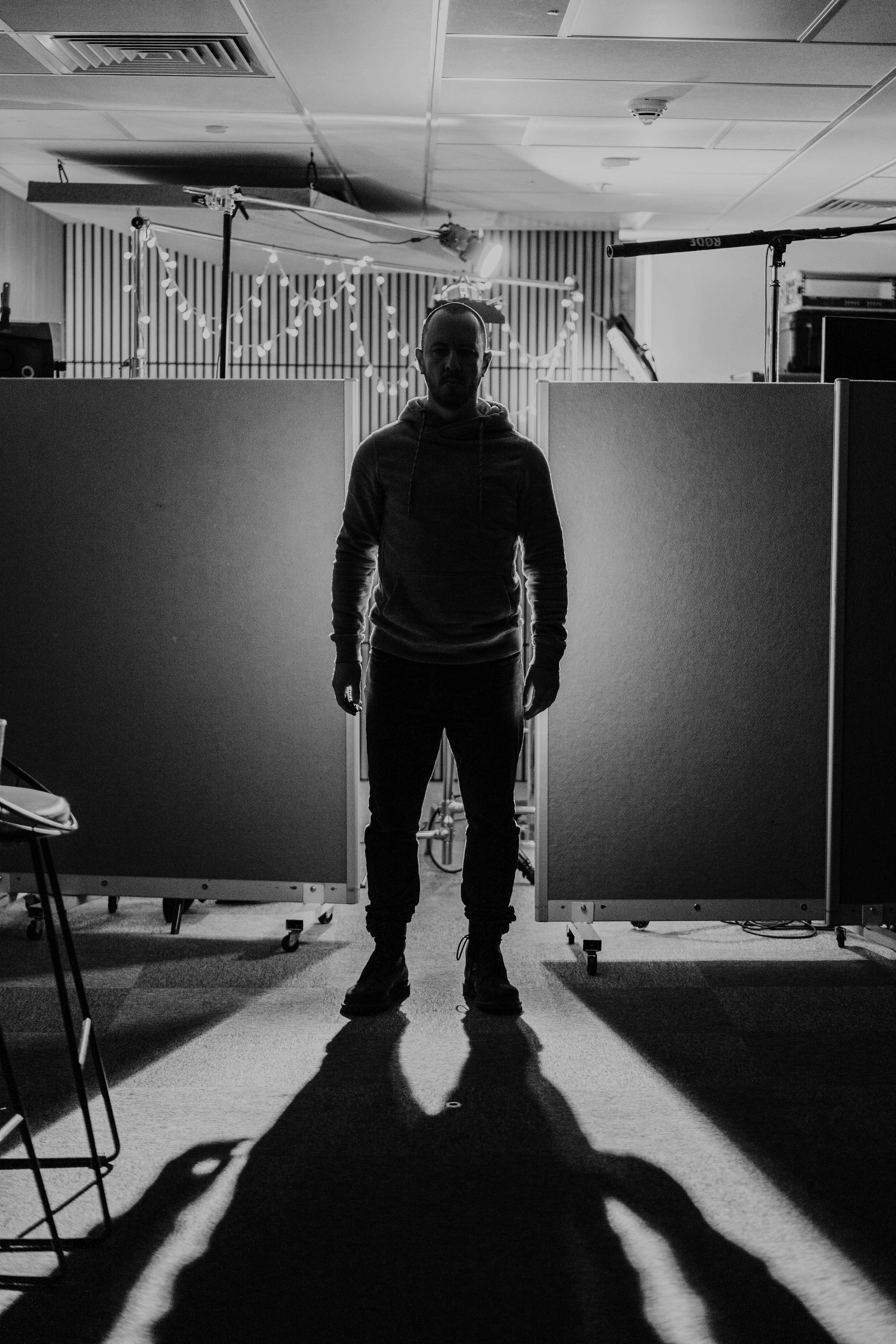 Backlit Silhouette Between Studio Partitions in a Quiet Monochrome Studio