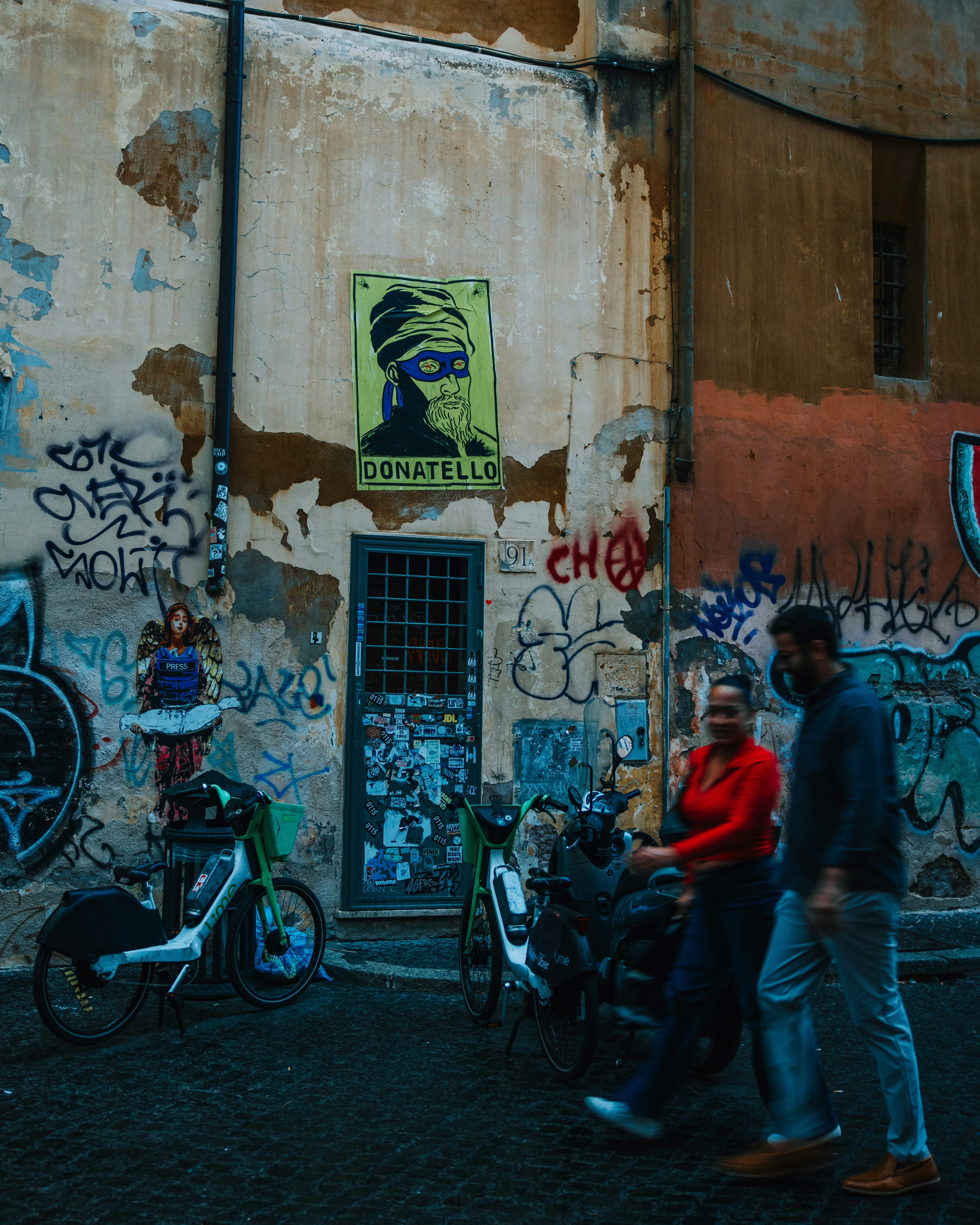 Vibrant street art featuring a stylized depiction of Donatello, surrounded by urban graffiti and bicycles parked nearby.