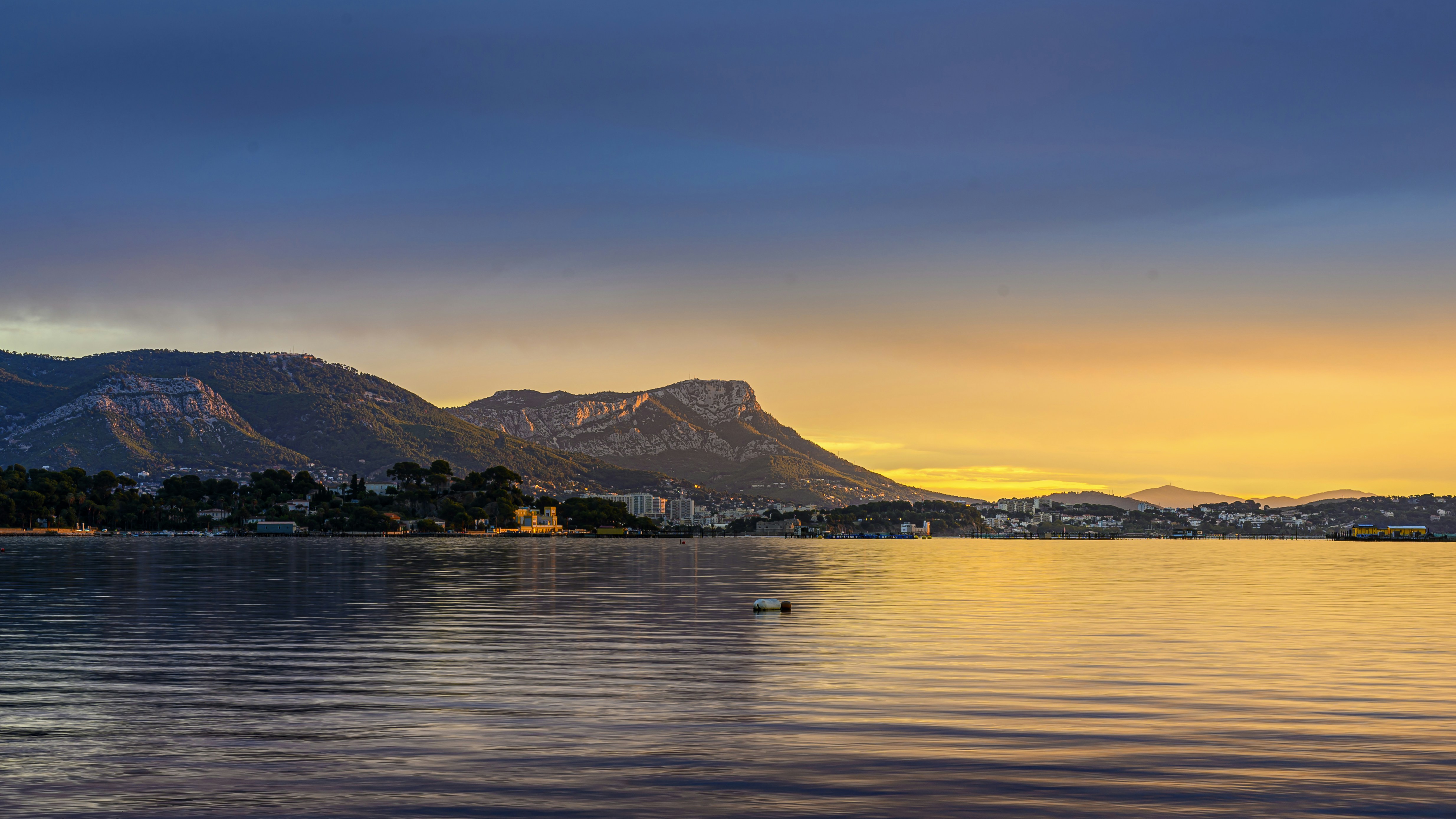 Coastal town with mountains at sunset
