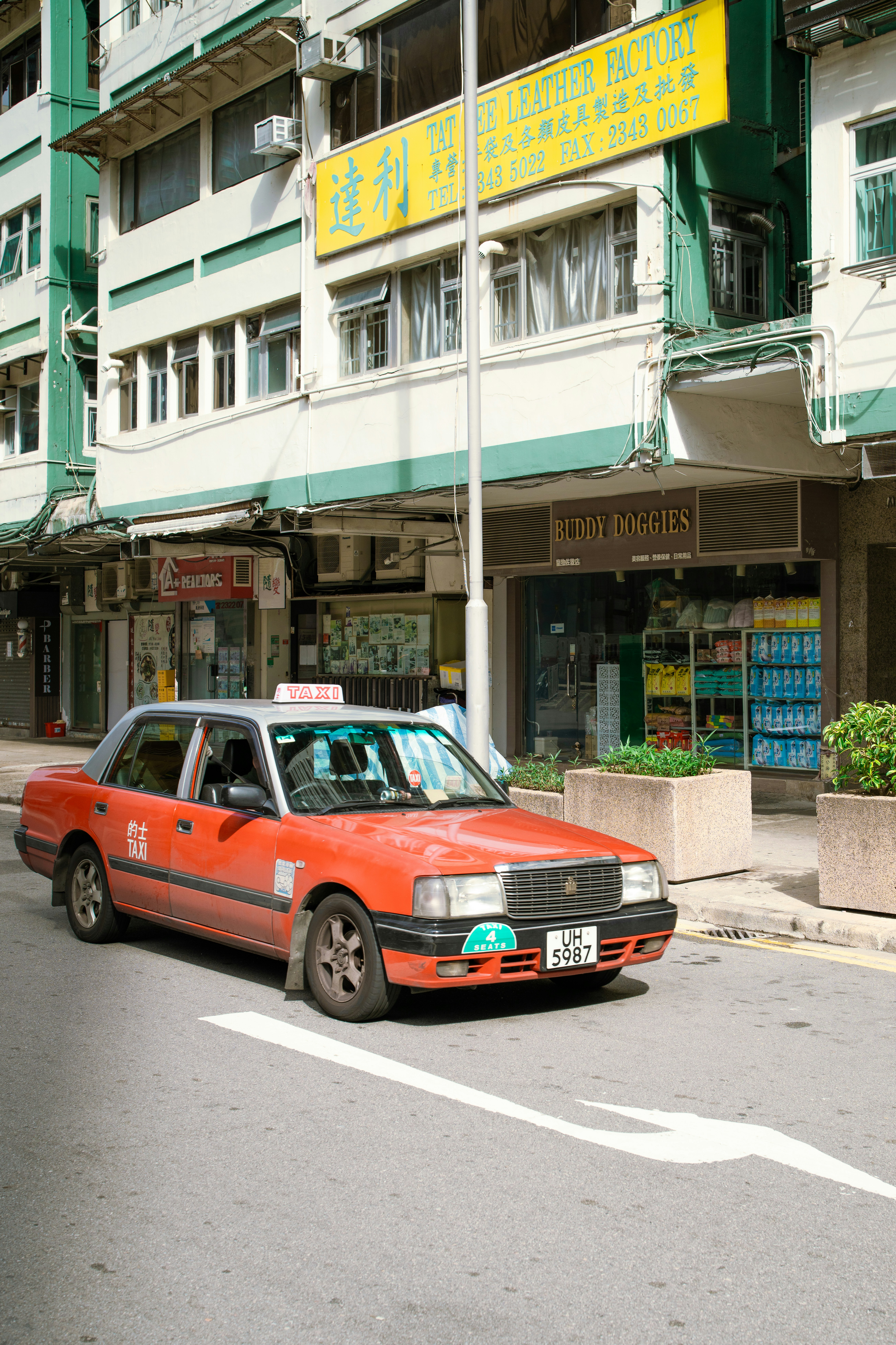 Red taxi driving on a city street.