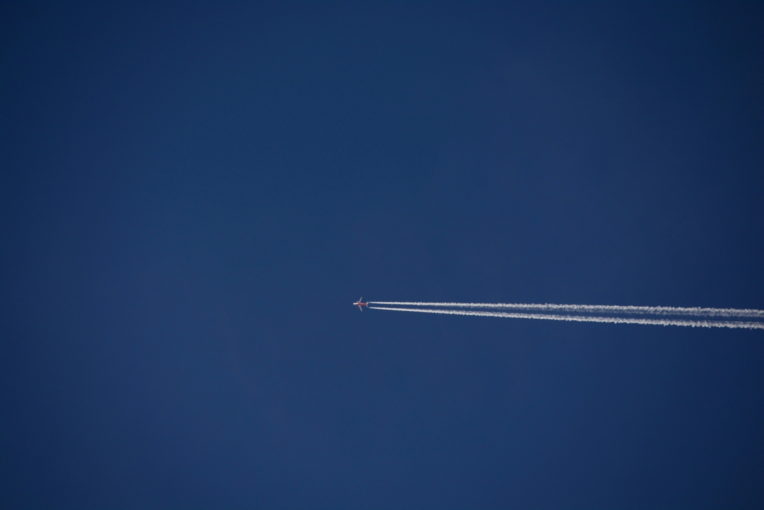 Airplane leaving a contrail across a clear blue sky