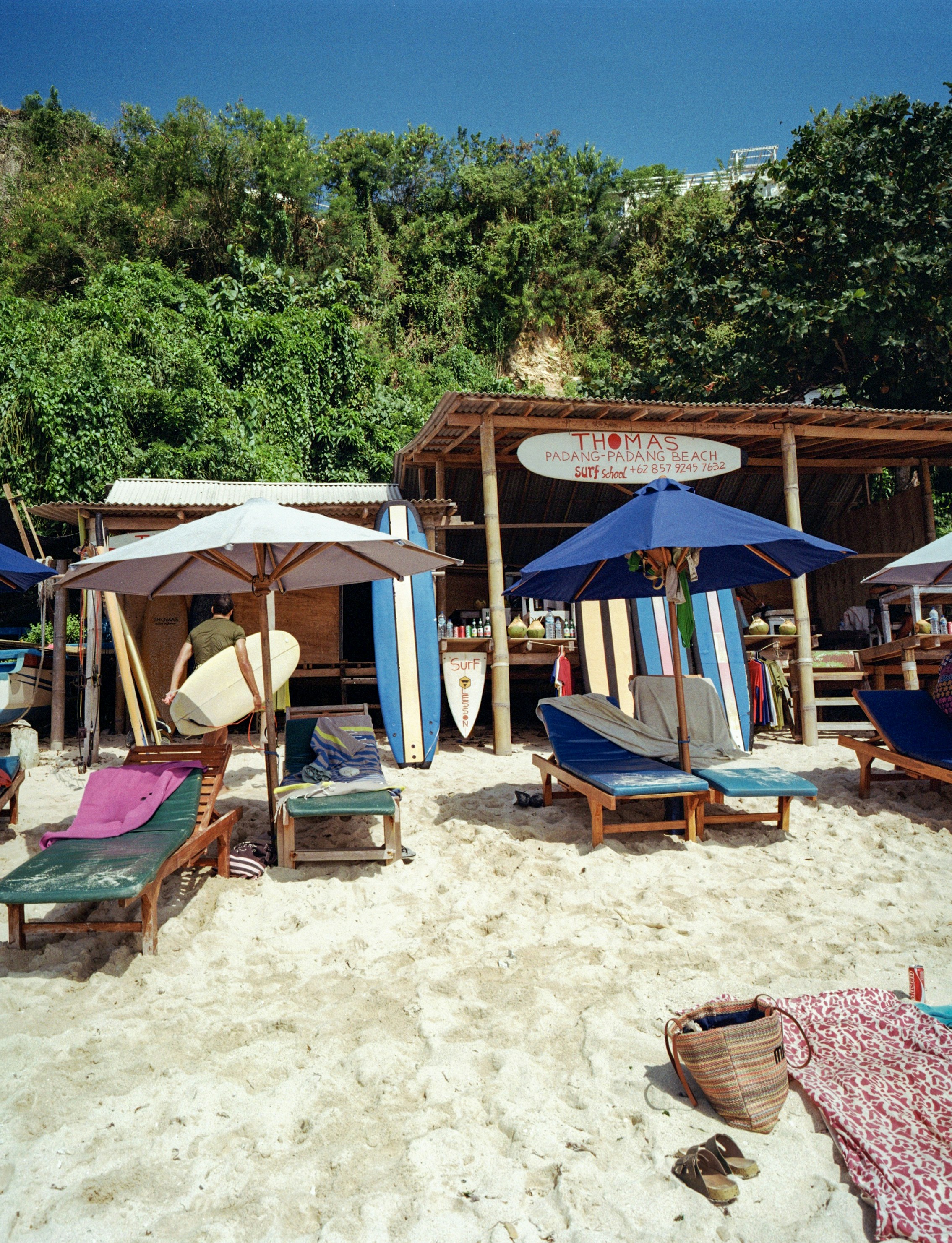Kodak Gold 200 🎞️ | Beach chairs and surfboards under umbrellas on sand.