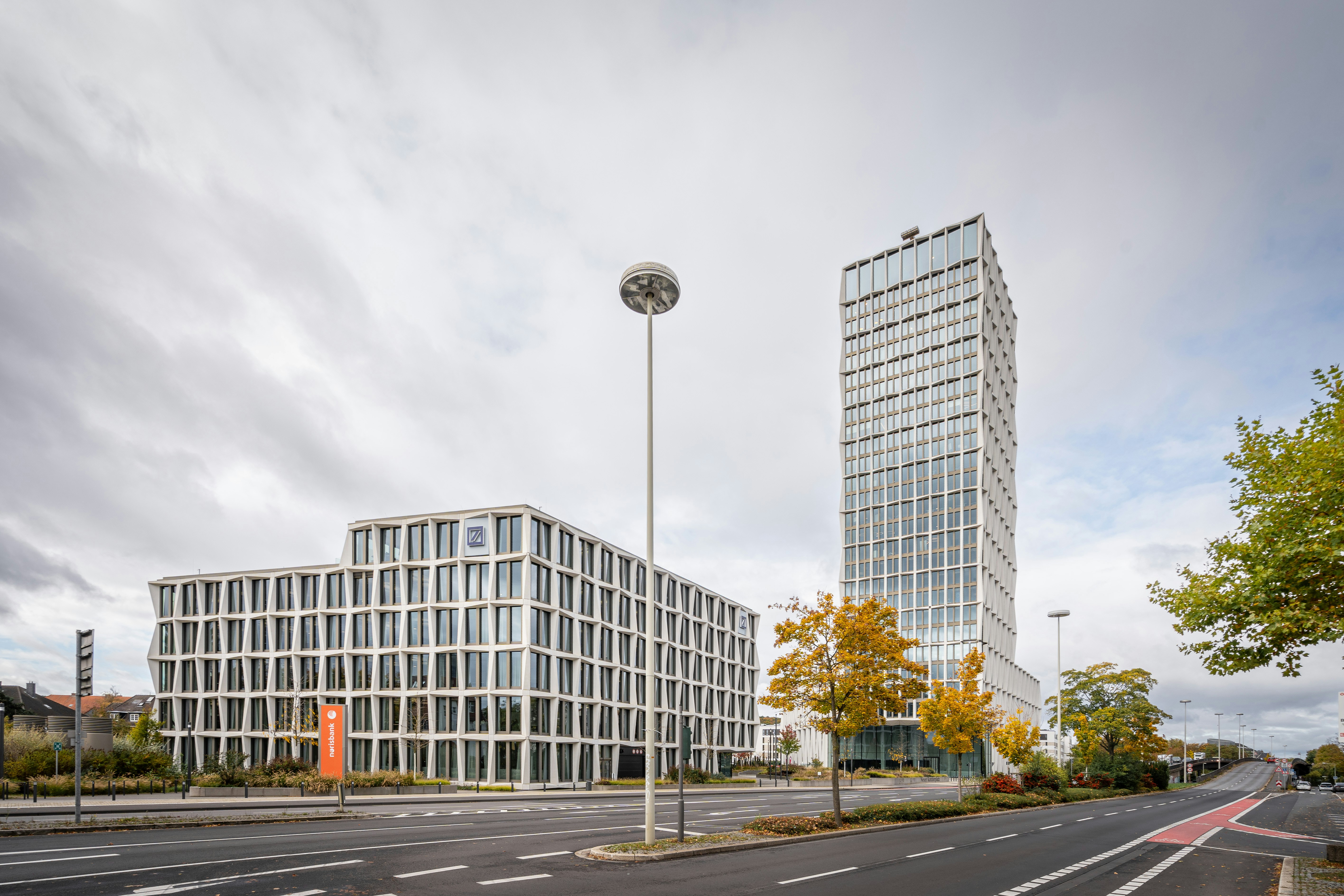 Contemporary buildings stand in harmony along a city street, showcasing innovative design and urban planning.