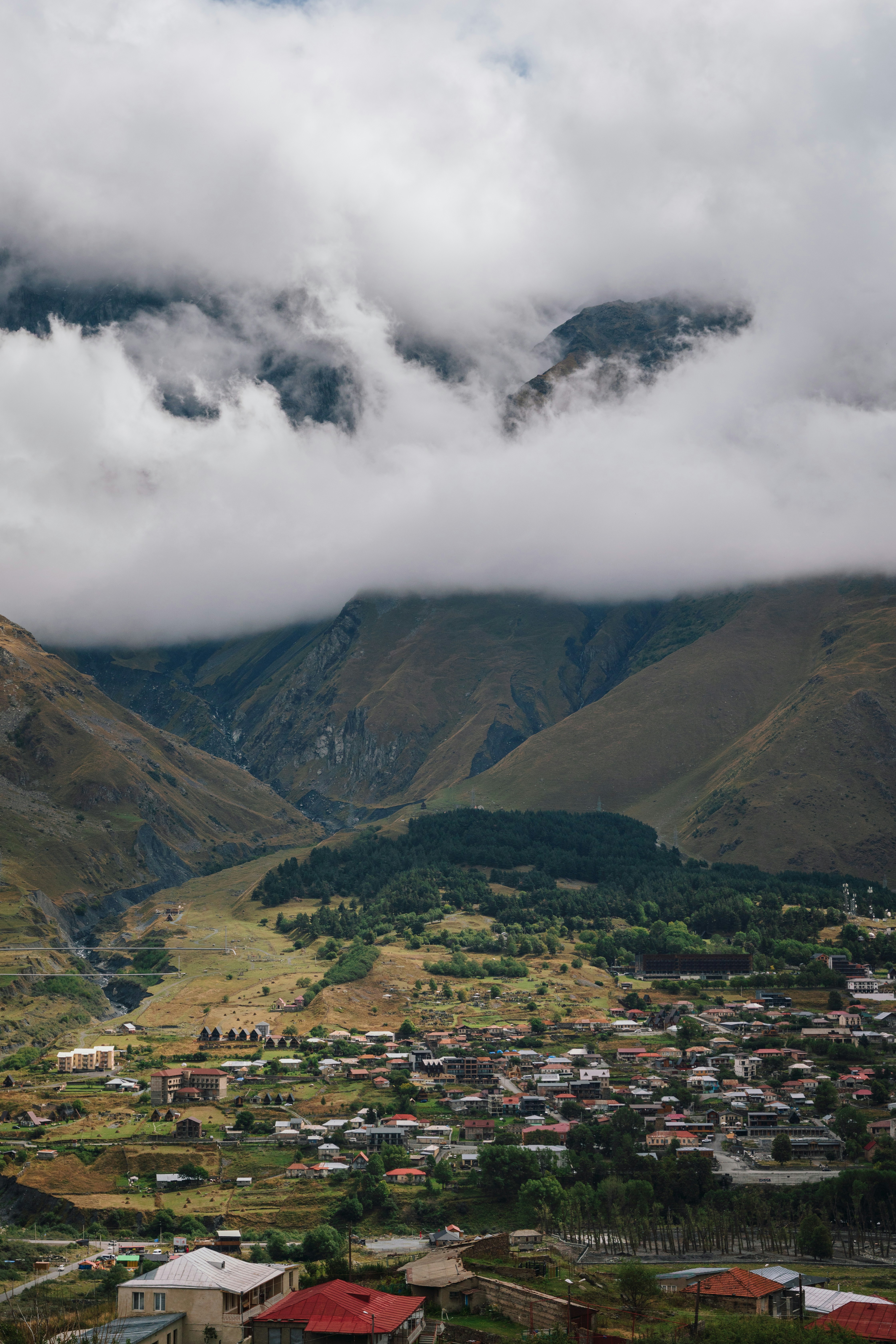 A village nestled in a valley surrounded by mountains.