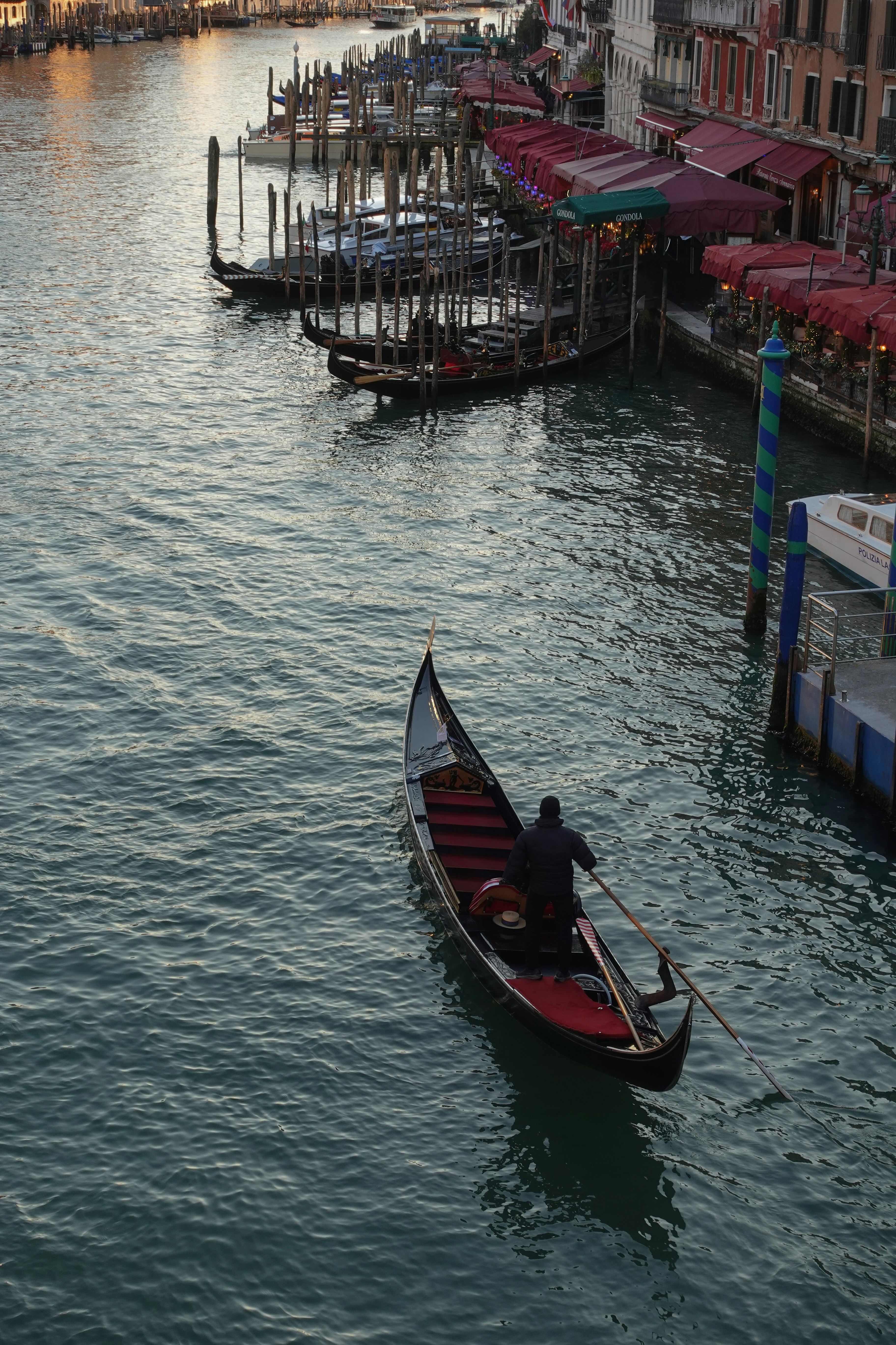 Gondolier’s Quiet Glide Through Venice’s Water-Lit Canal