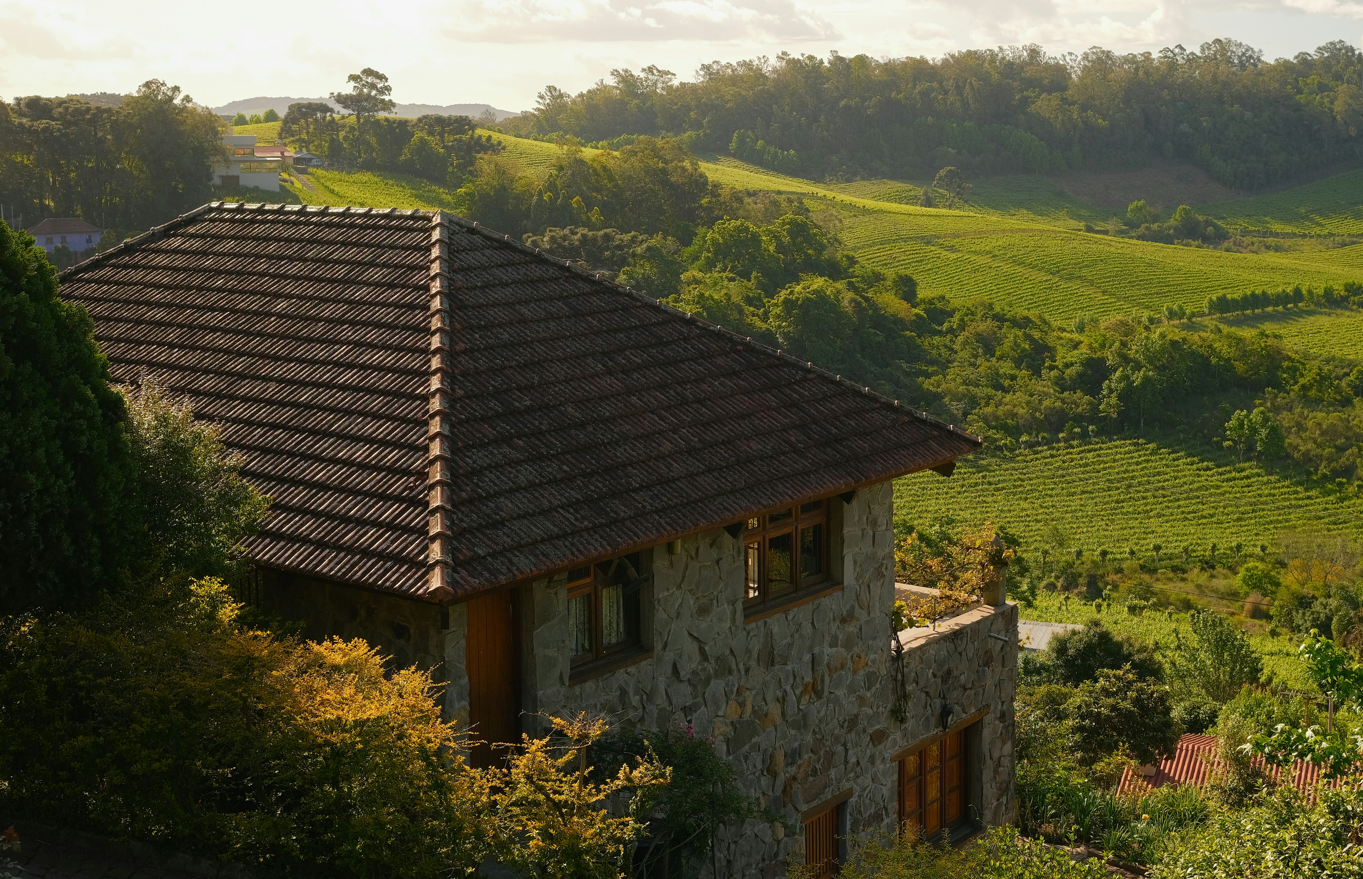 Fotografia para Pousada Borguetto, Bento Gonçalves, Serra Gaúcha. | Stone house nestled in rolling green hills.