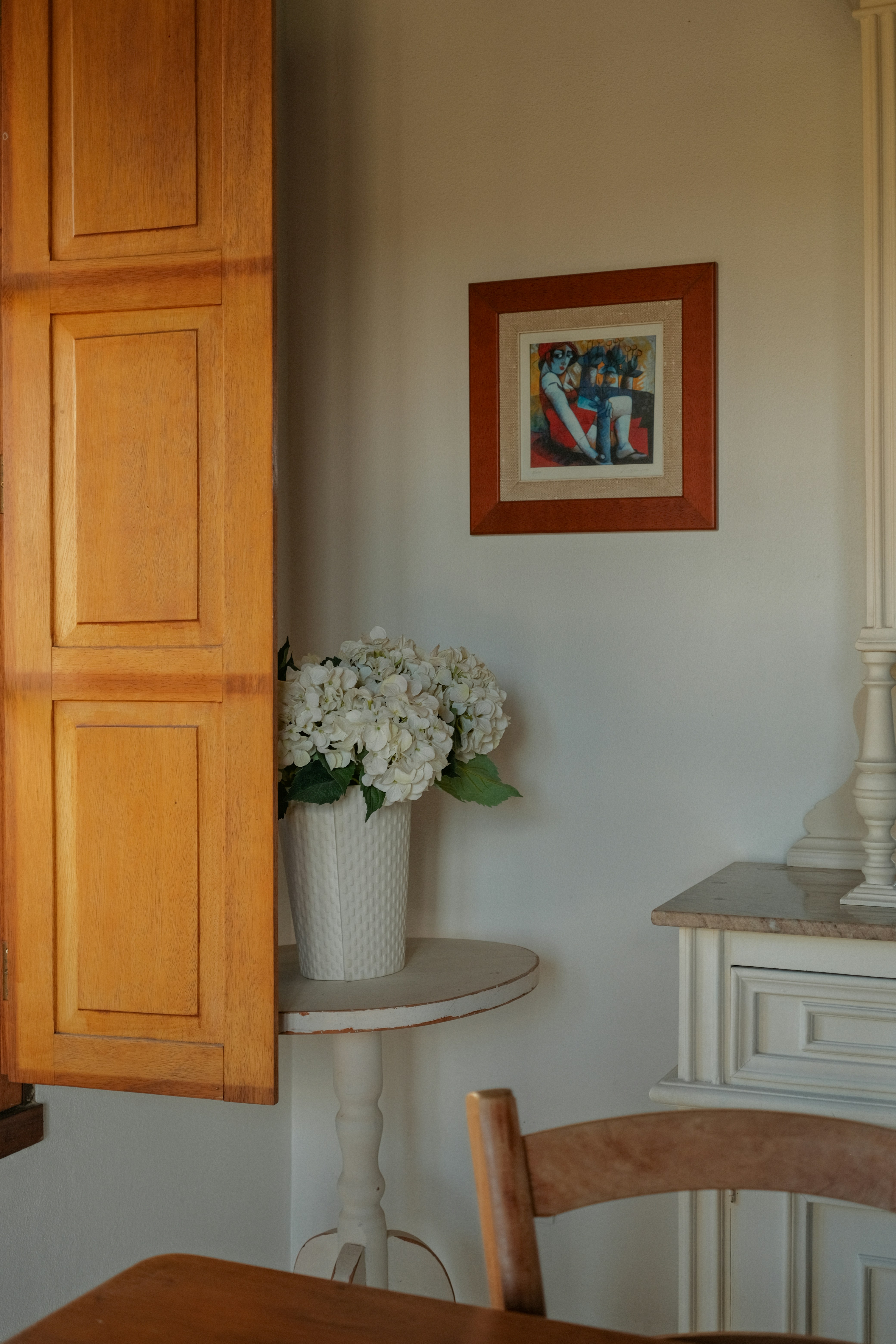 Fotografia para Pousada Borguetto, Bento Gonçalves, Serra Gaúcha. | Wooden shutters flank a vase of white flowers.