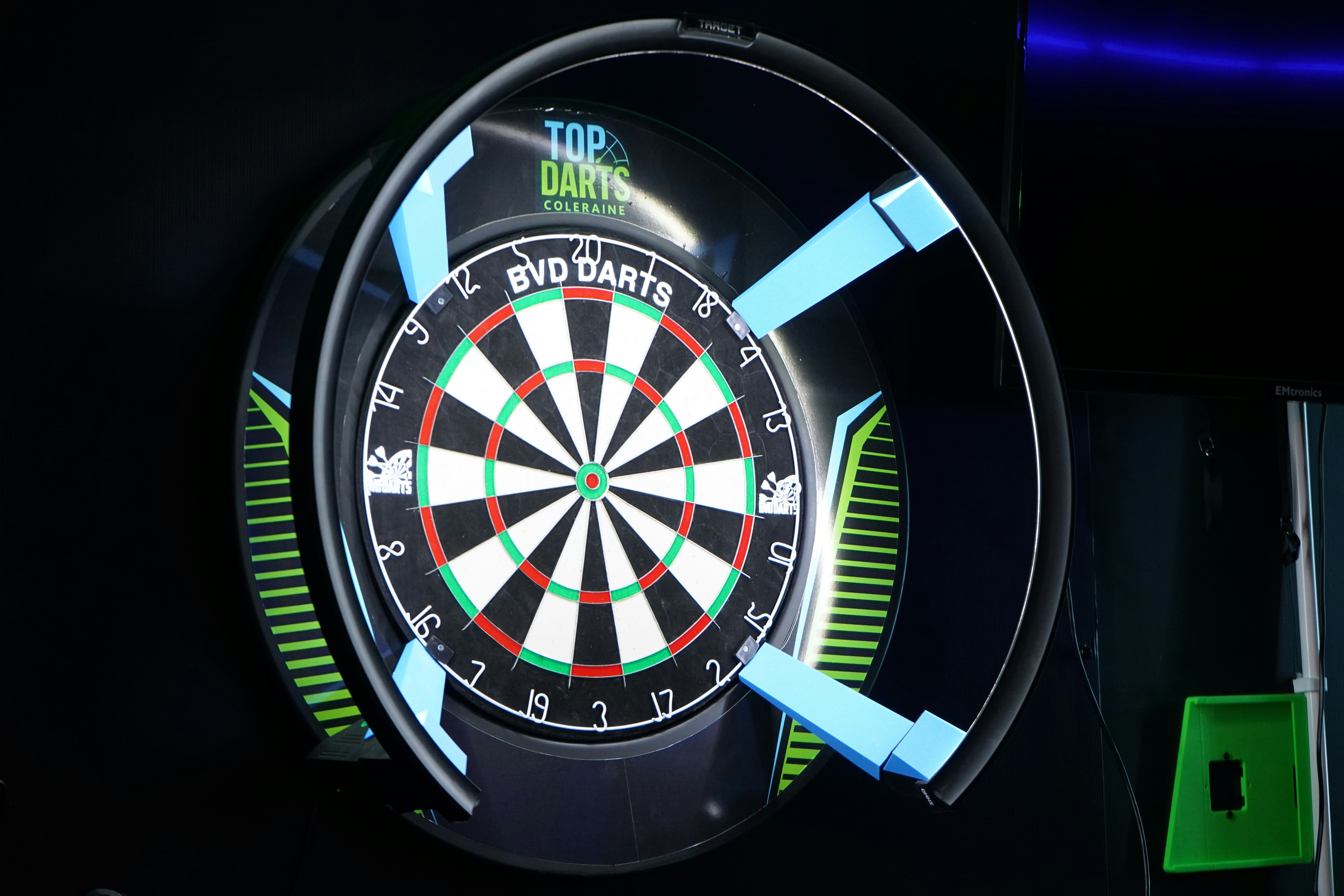 Illuminated dartboard featuring vibrant colors and clear markings, set against a dark background, enhancing the competitive atmosphere.