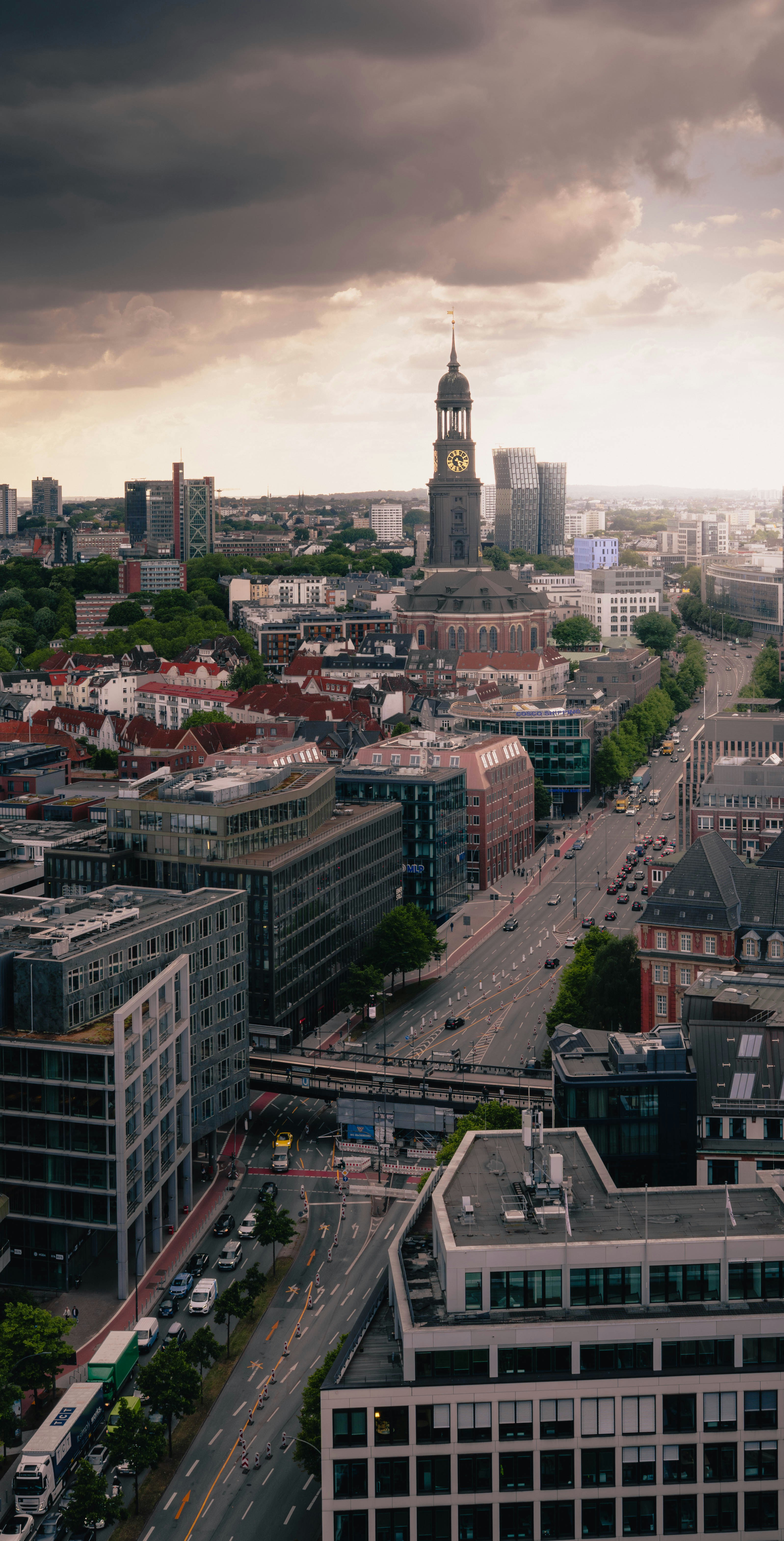 Cityscape with a tall clock tower under stormy clouds