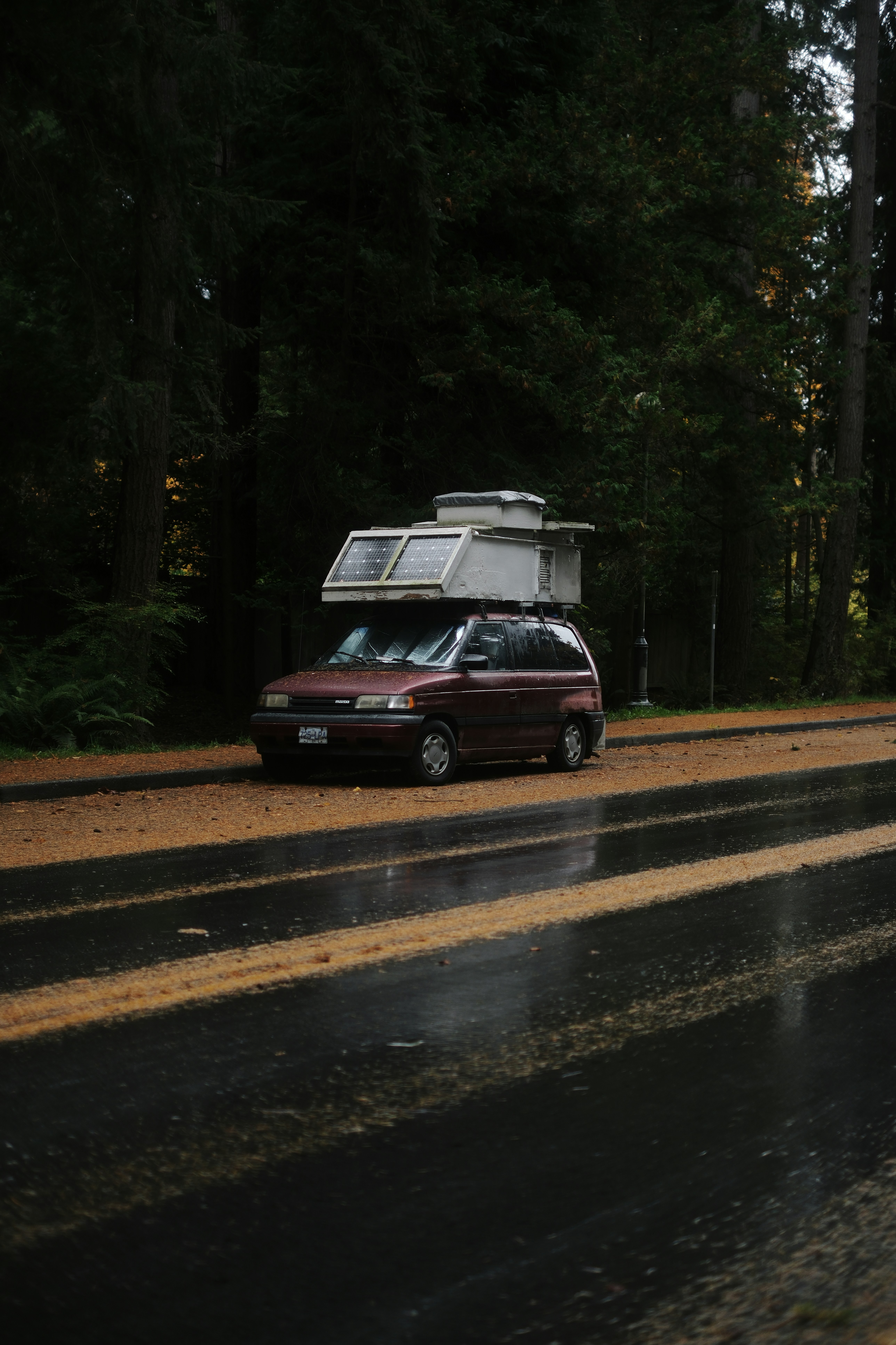 Instagram - @kaprion | Maroon minivan with camper shell on a wet road.