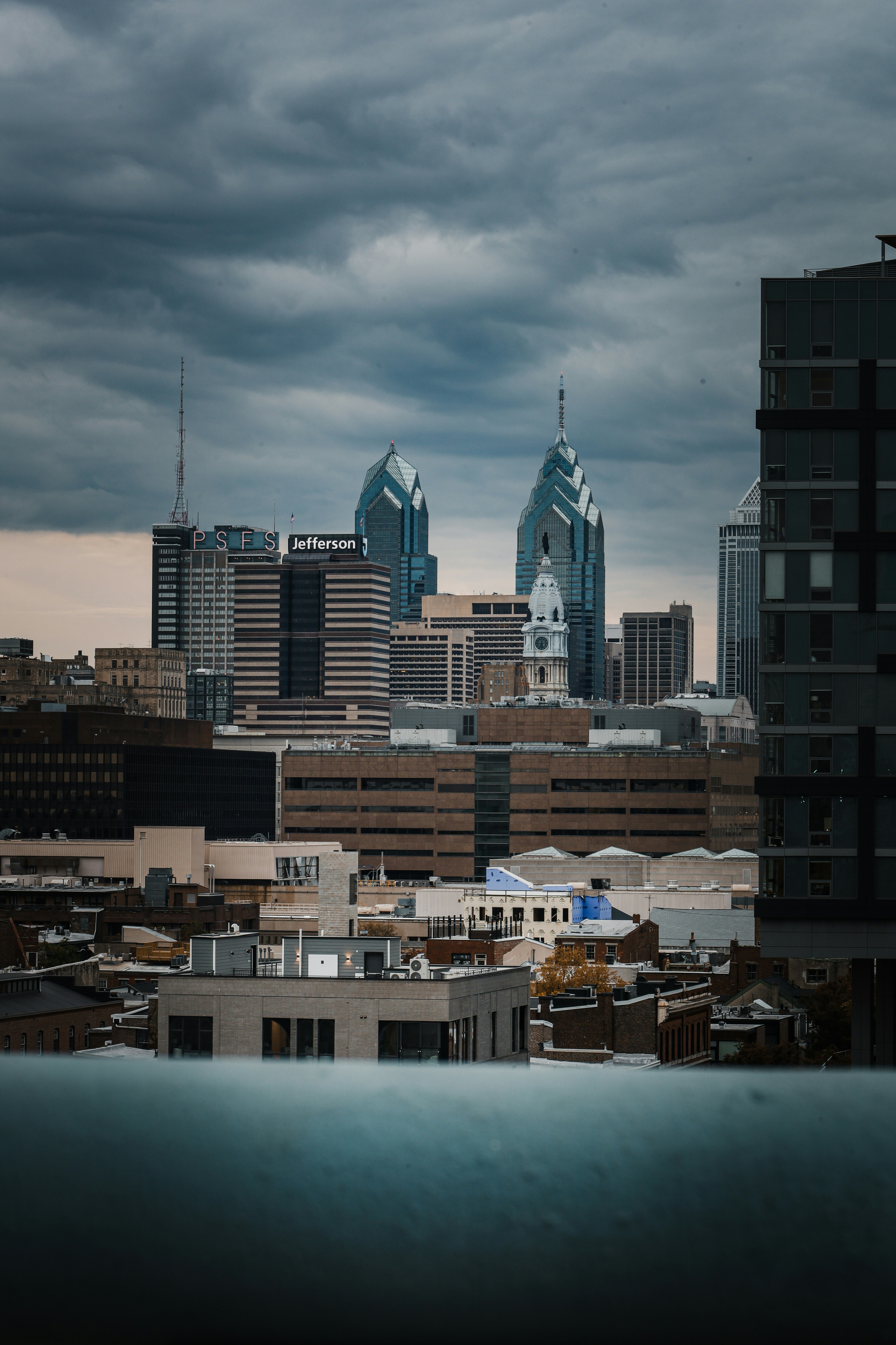 City skyline under a dramatic, cloudy sky.